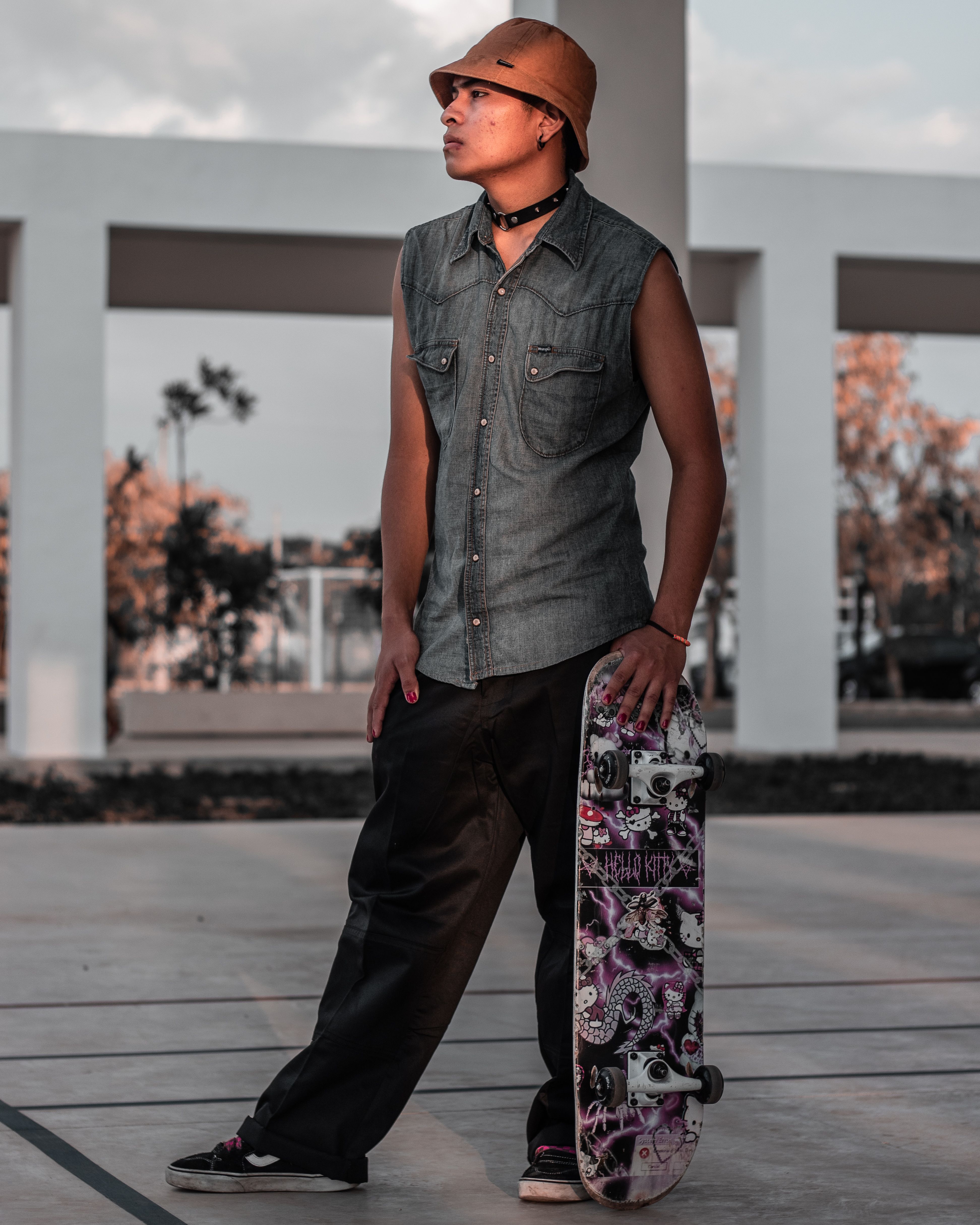 Man Wearing a Denim Vest Holding His Skateboard · Free Stock Photo