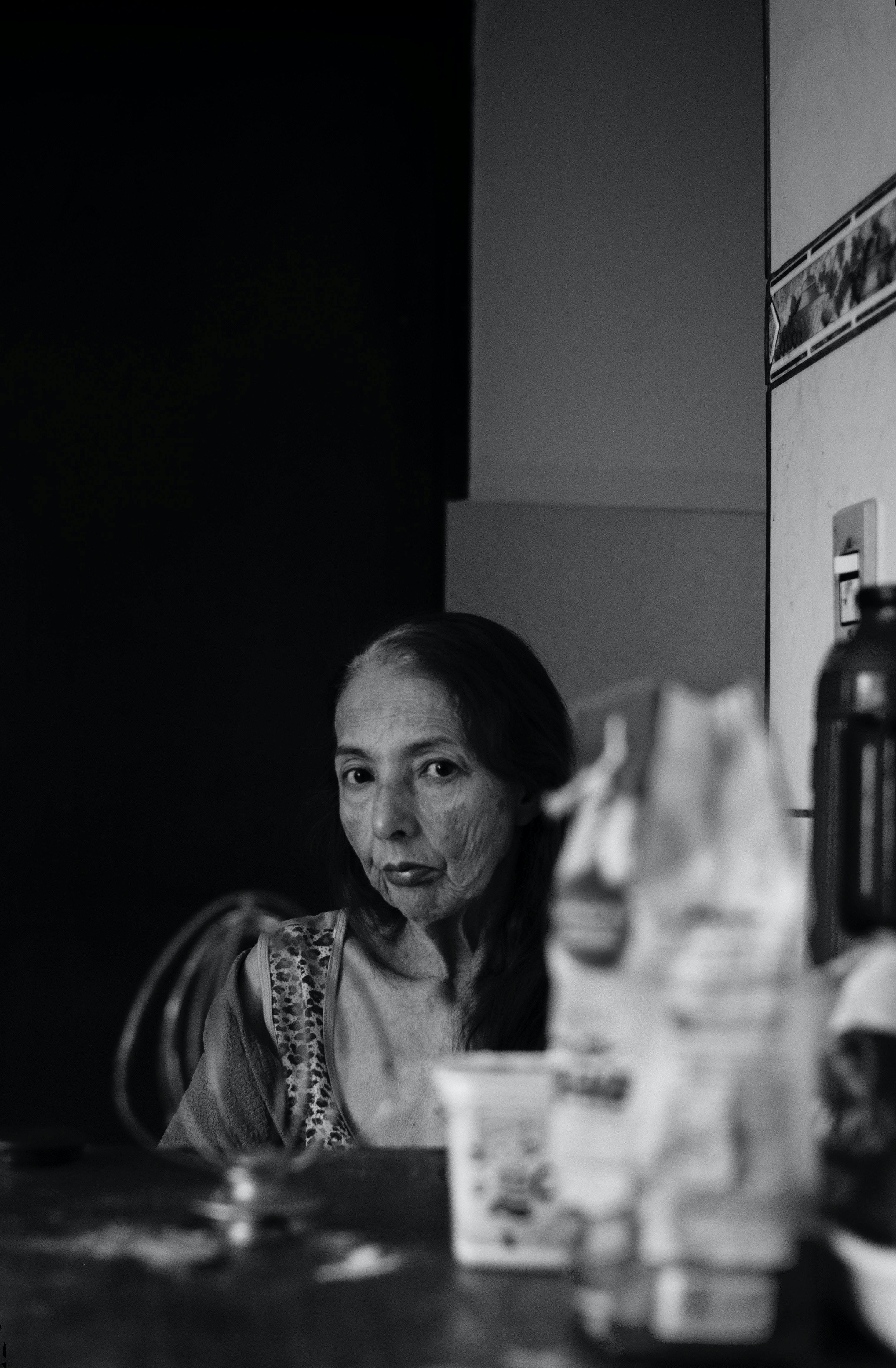 Elderly Woman Sitting Behind the Table · Free Stock Photo