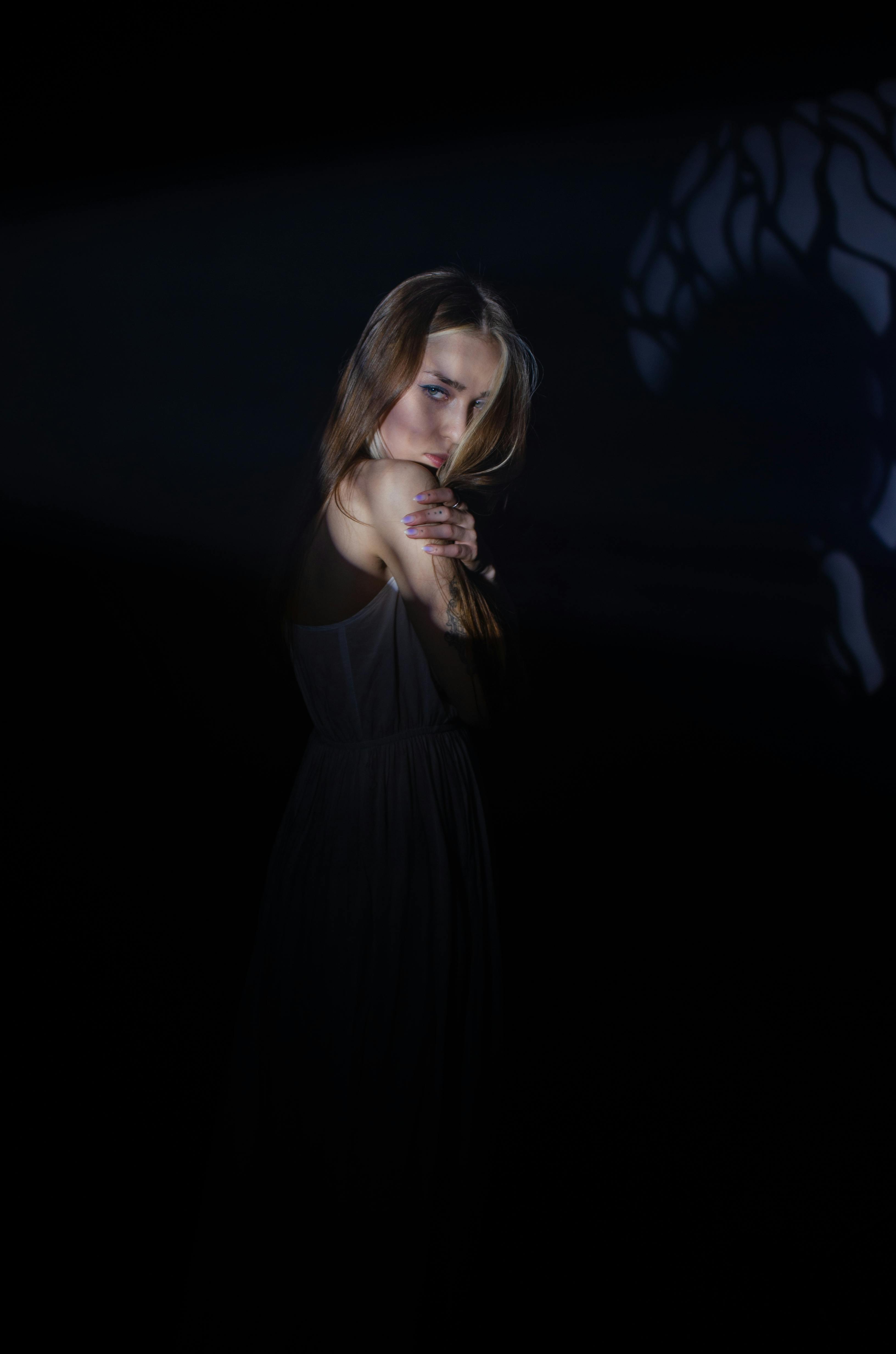 Woman with Light Shadow Posing in Dark · Free Stock Photo