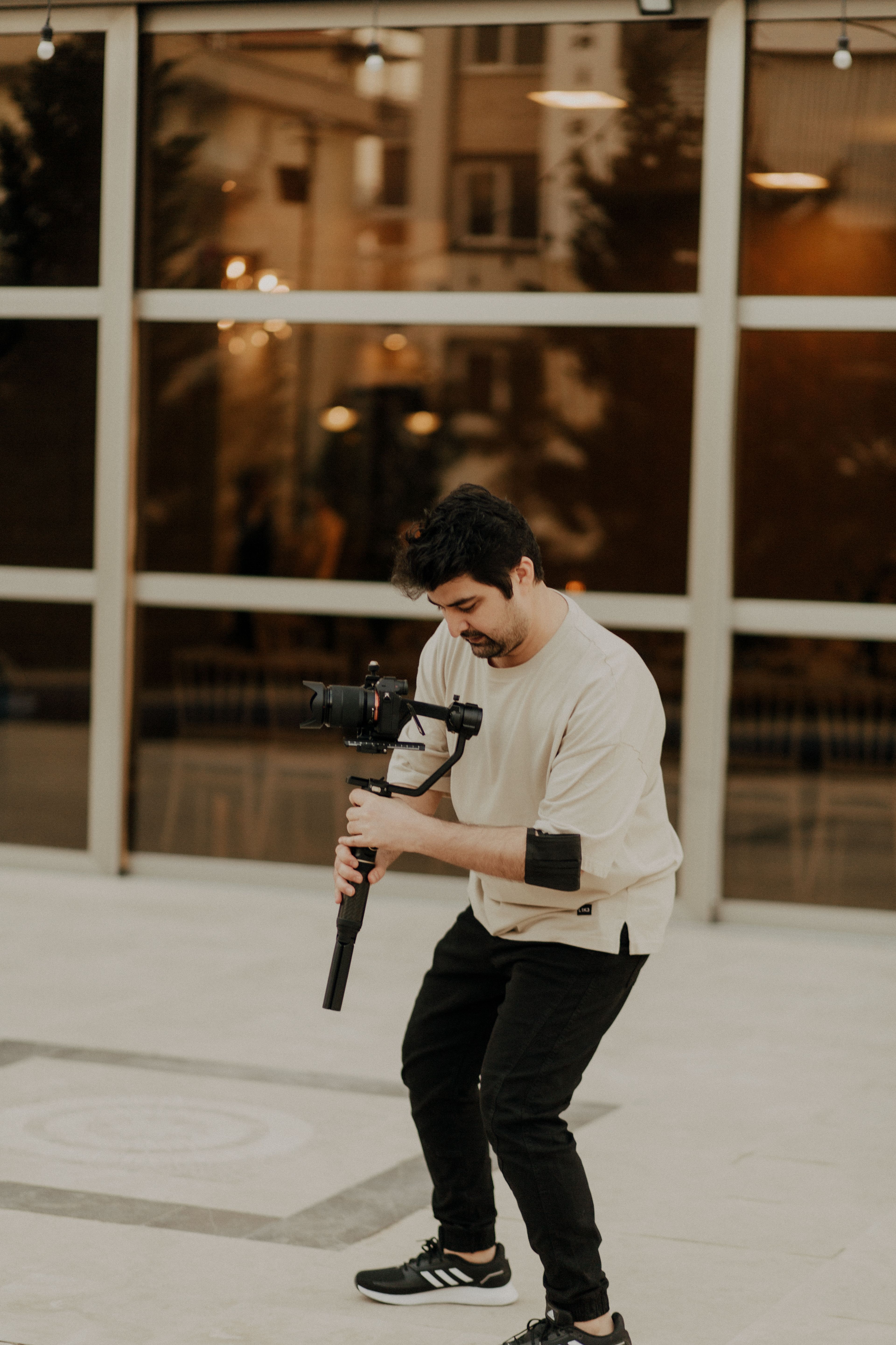 A Man in Puffer Jacket Holding a Camera with Tripod · Free Stock Photo