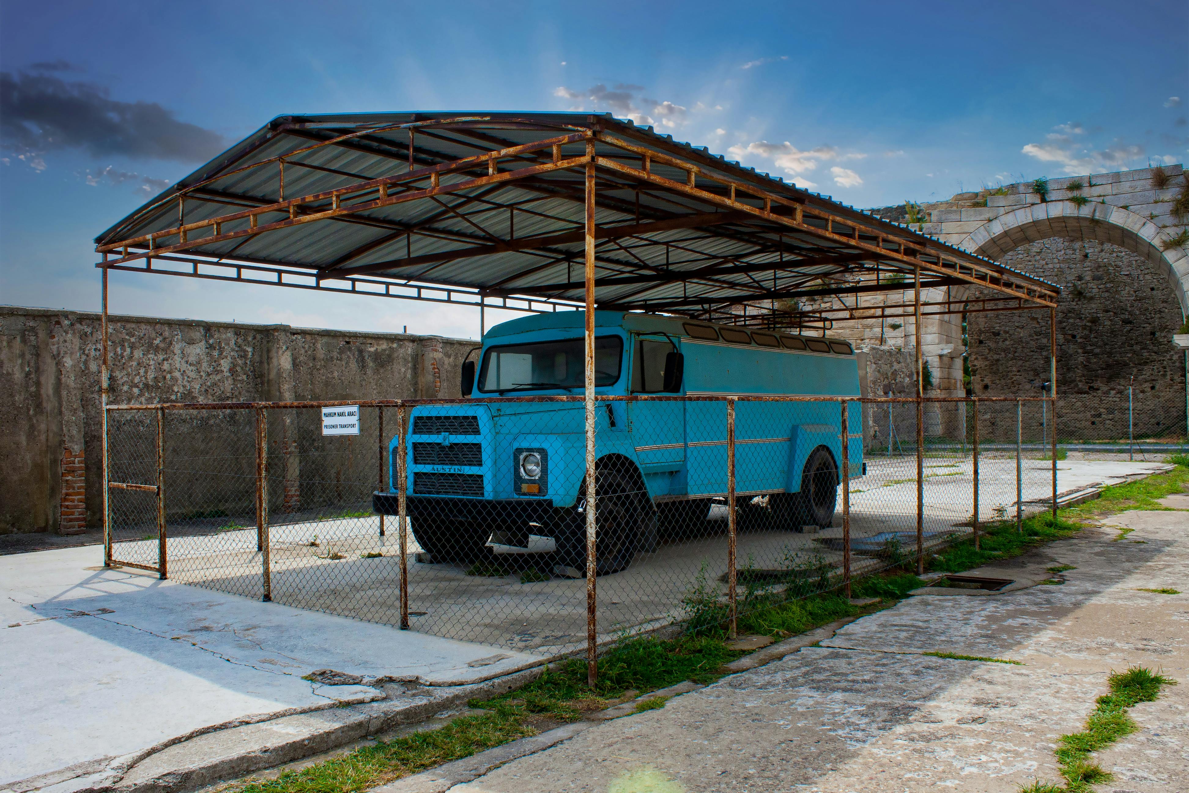 Parked Blue Bus inside a Chain-link Fence · Free Stock Photo