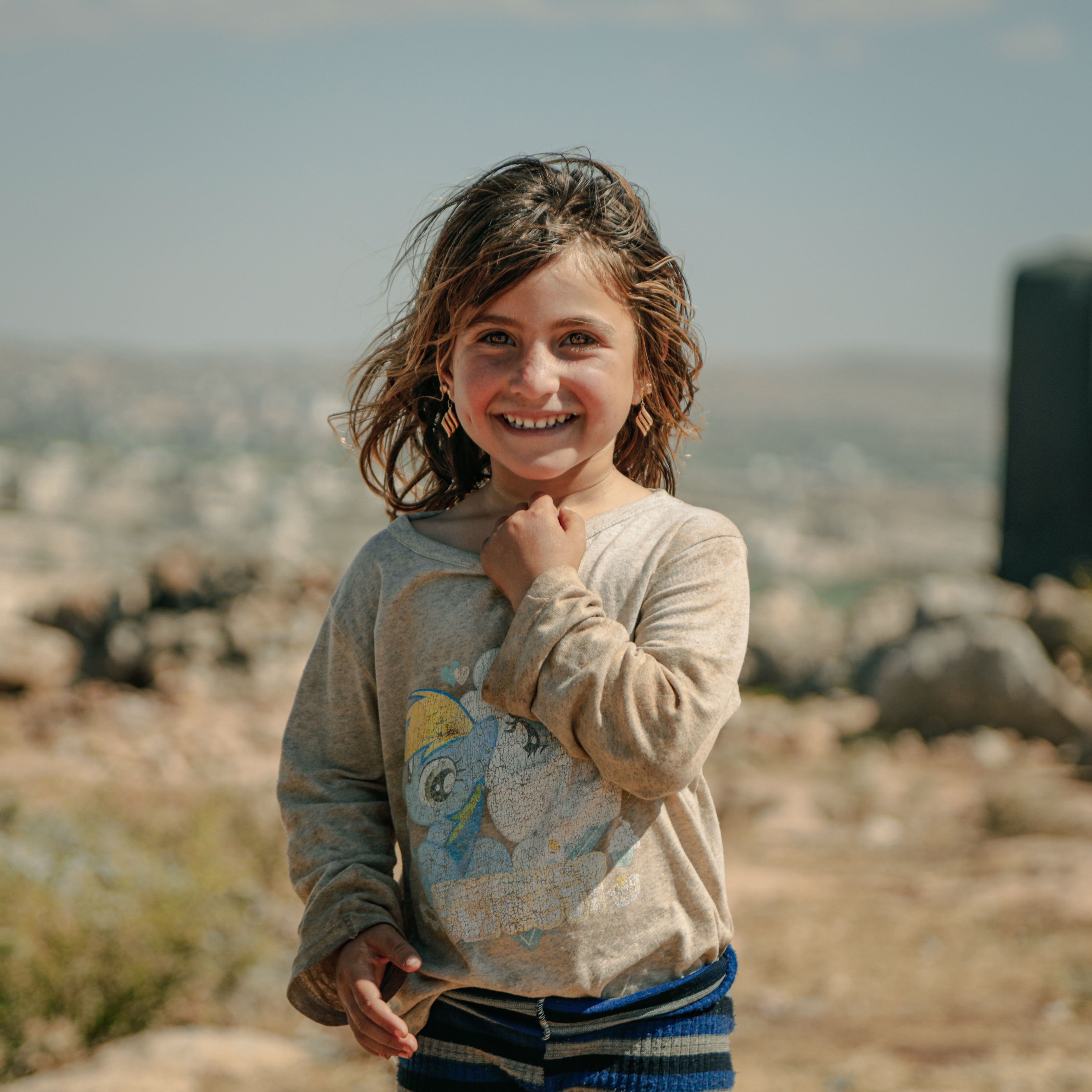 Smiling Kid with Hand on Neck · Free Stock Photo