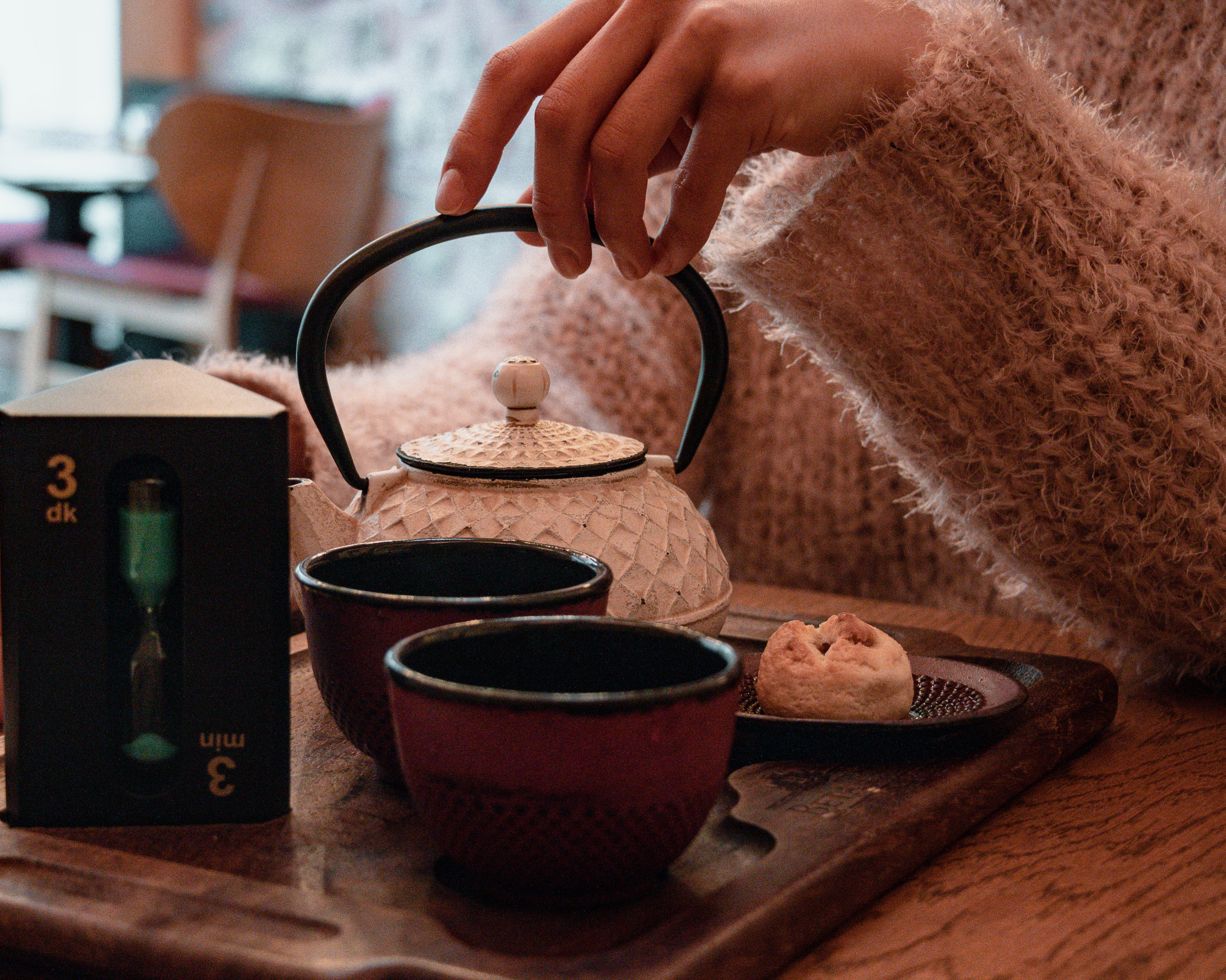 Person Holding Black and White Ceramic Teapot · Free Stock Photo