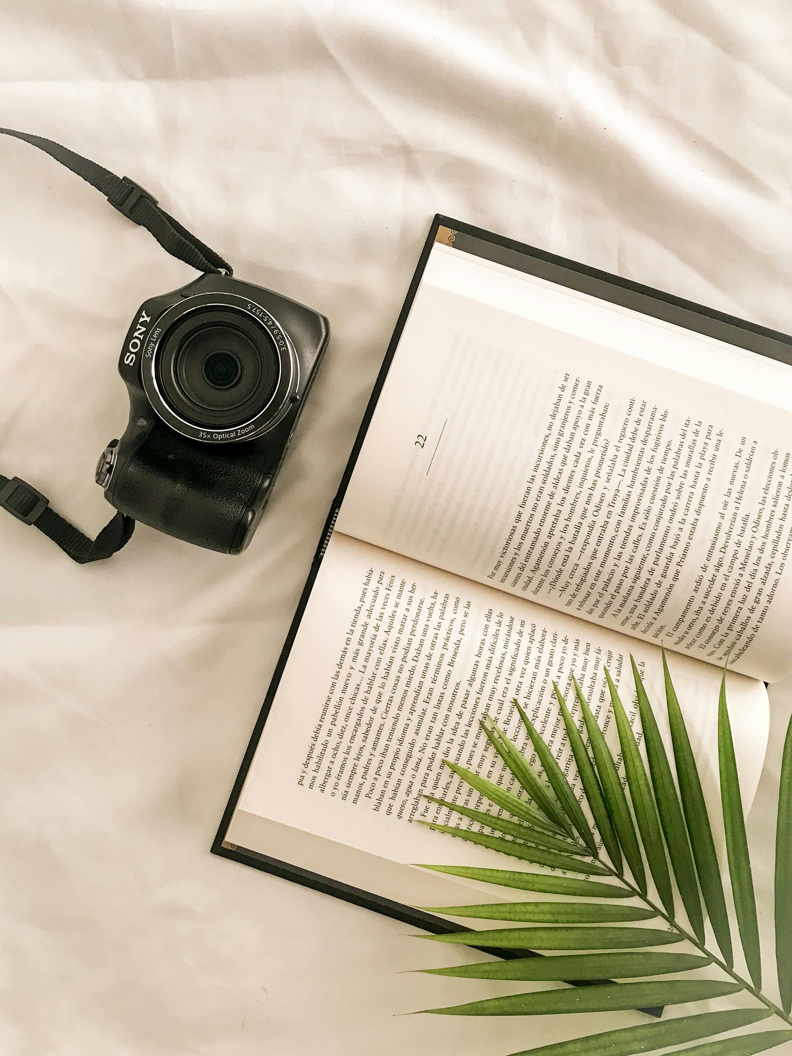 Open Book and Camera Lens on Carpet · Free Stock Photo