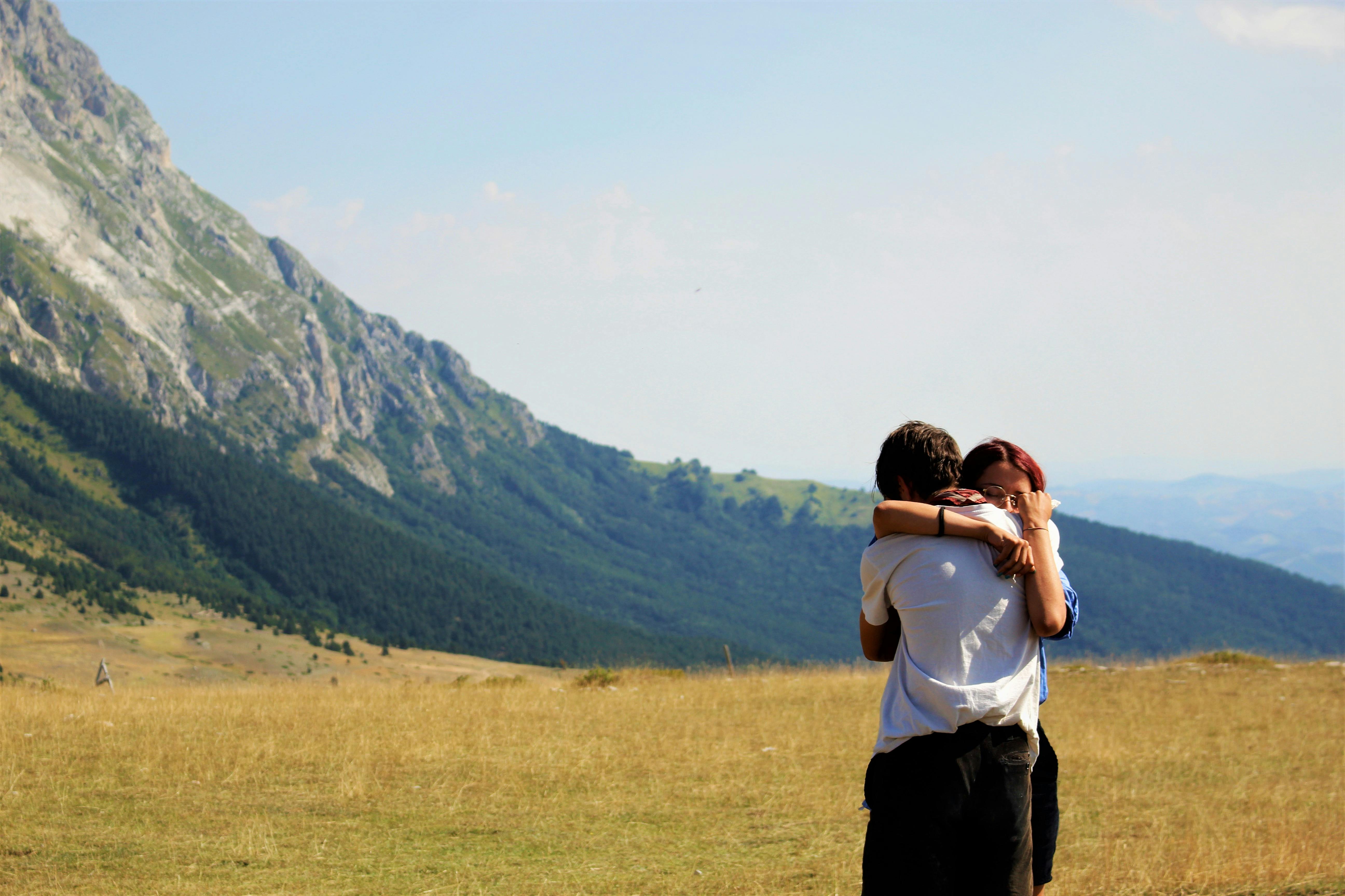 Back View of a Couple Hugging on the Grass Field · Free Stock Photo