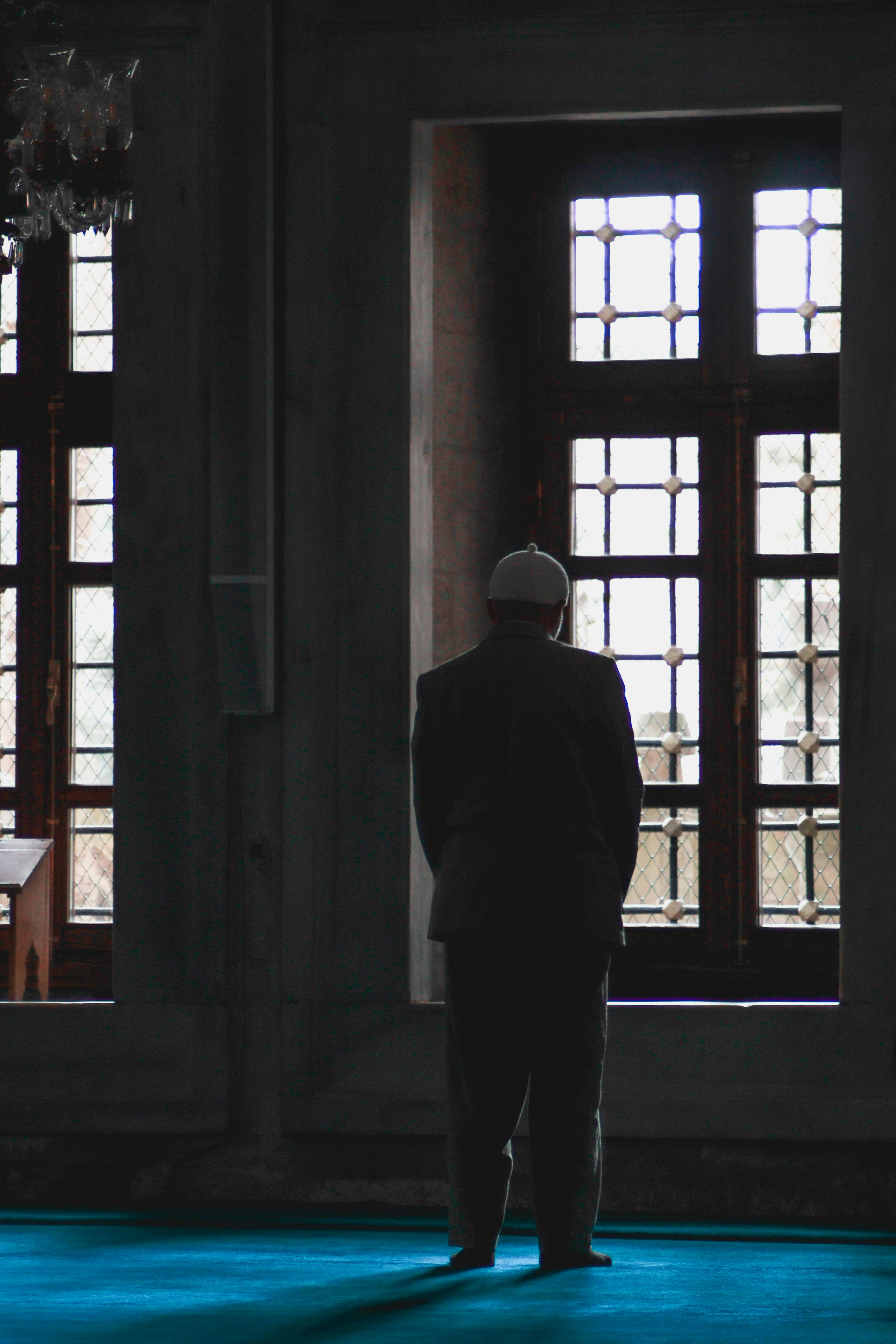 Man Standing near Windows in Mosque · Free Stock Photo