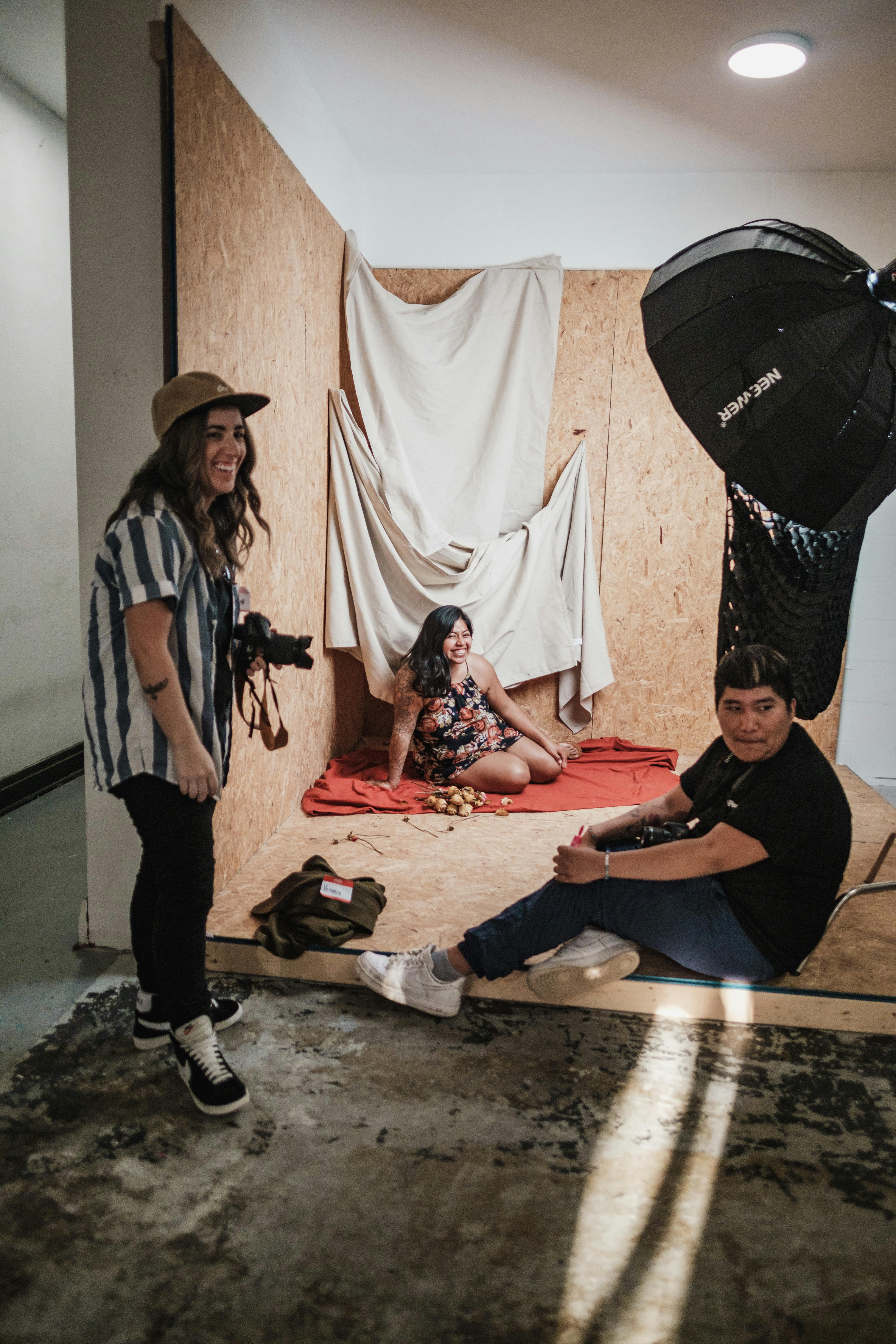 People Sitting on a Floor with a Photographer Holding Camera Inside a ...