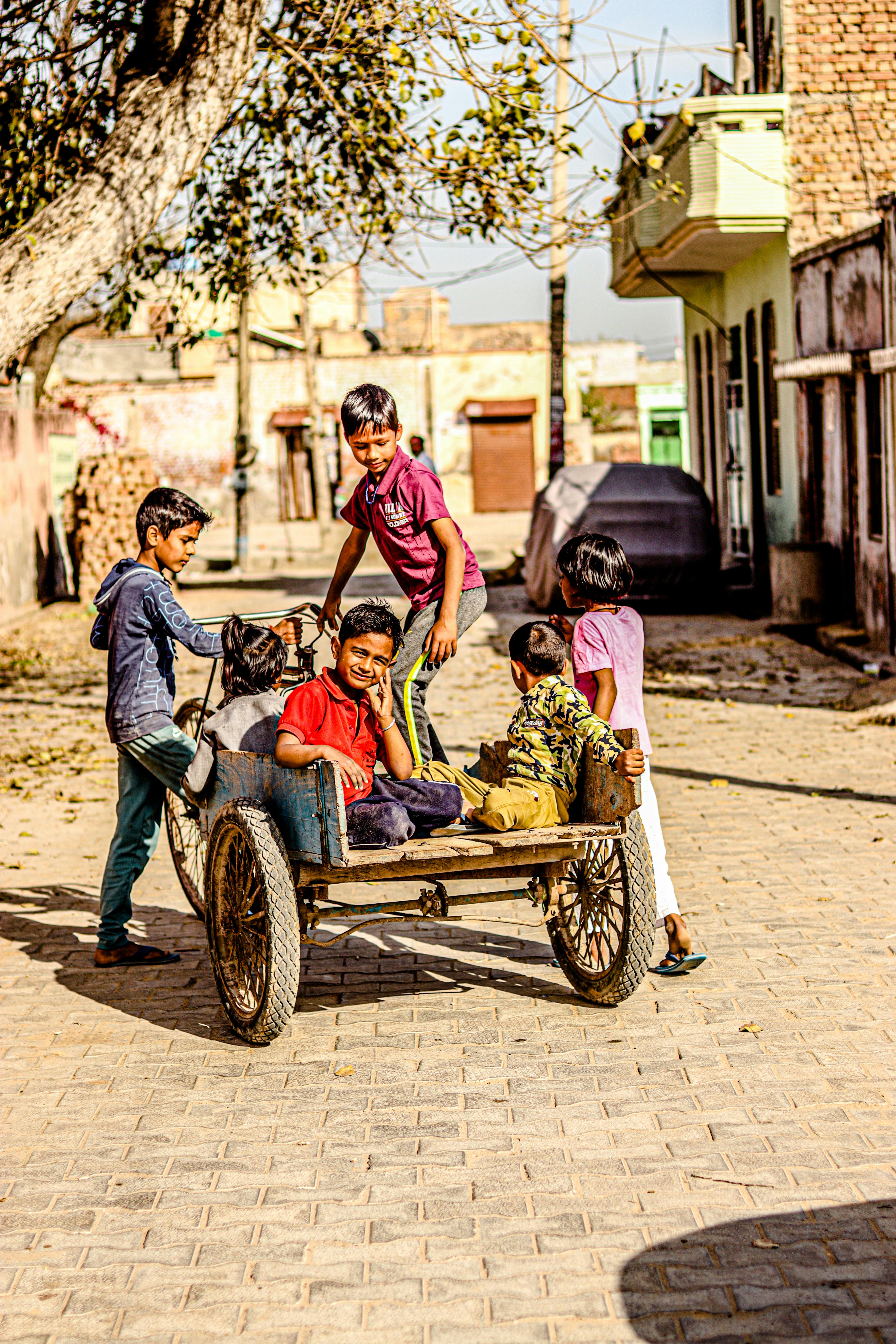 Children in a Carriage on a Sidewalk · Free Stock Photo