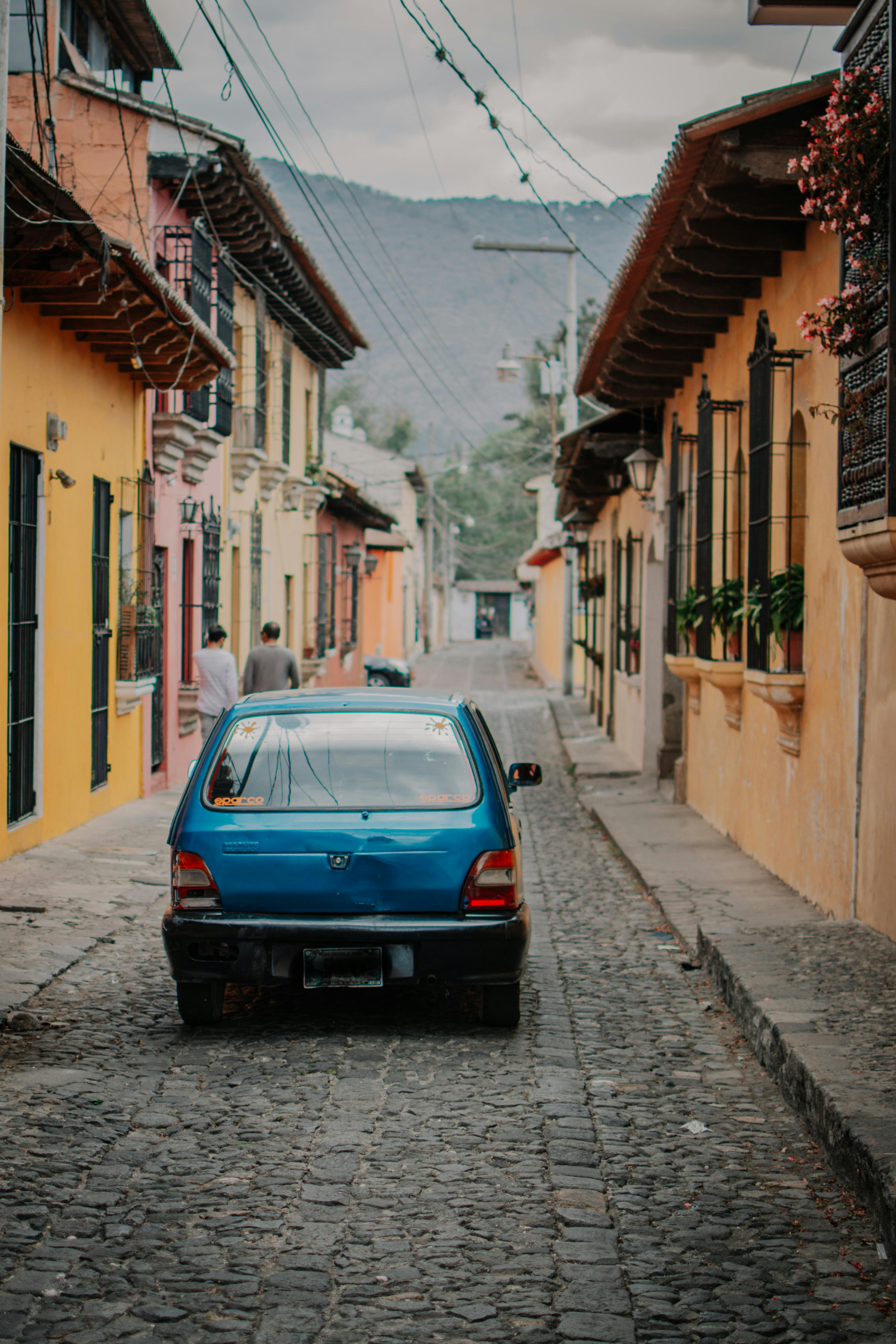Blue Car Driving on a Narrow Alley · Free Stock Photo
