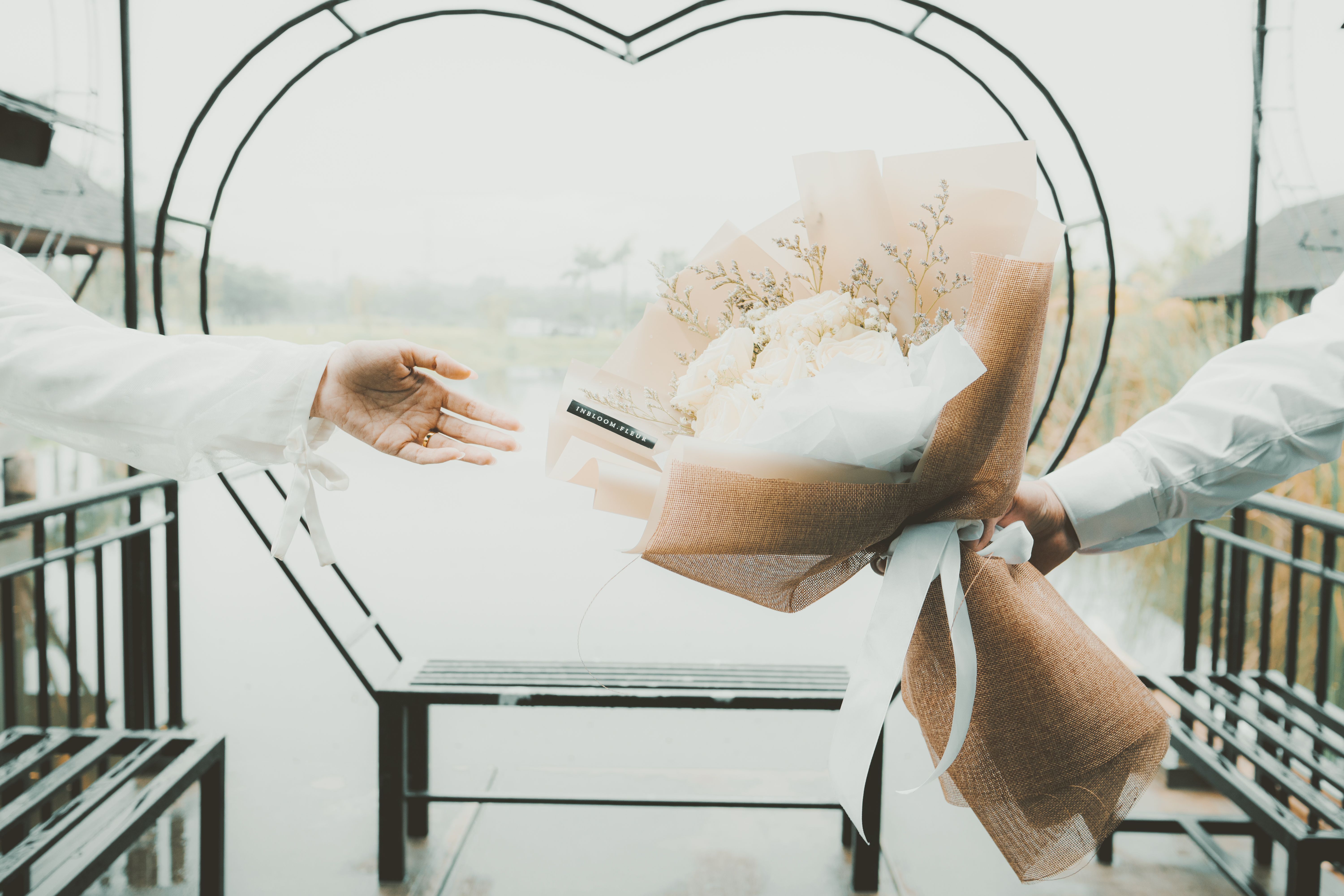 A Person Handing another Person a Bouquet of Flowers · Free Stock Photo