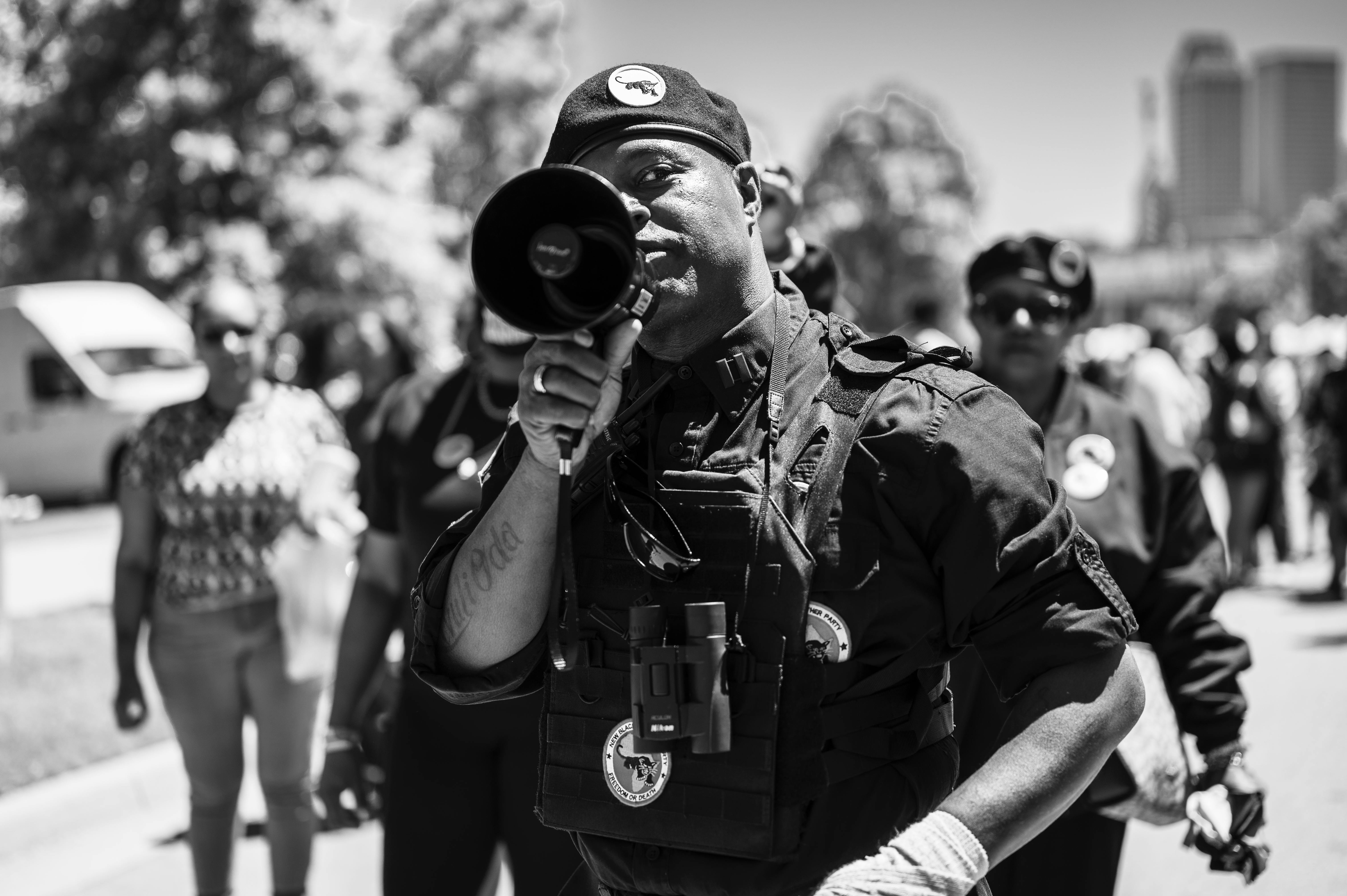 Grayscale Photo of a Policeman Talking using a Megaphone · Free Stock Photo