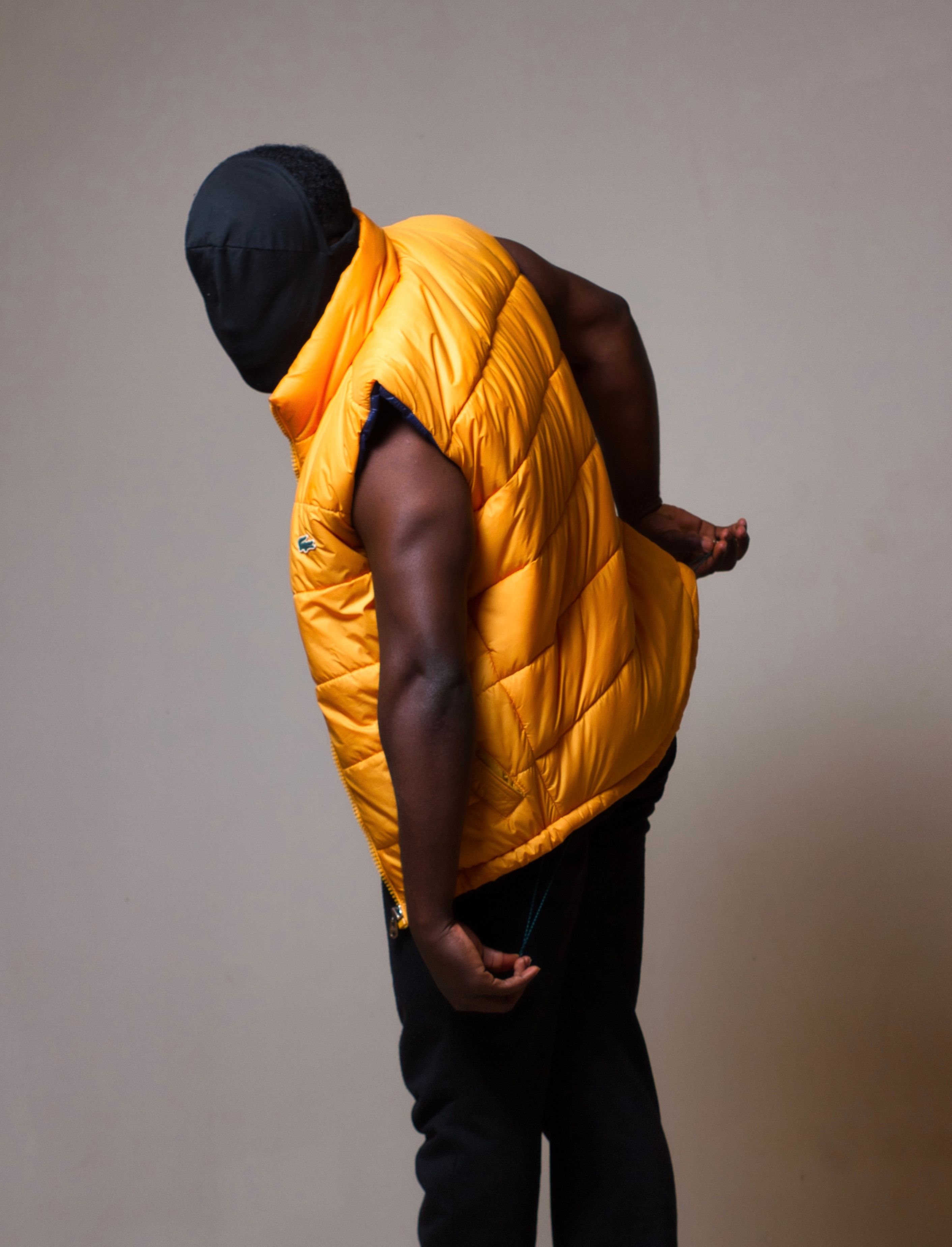 A Man in Yellow Vest Wearing Black Mask while Posing at the Camera ...