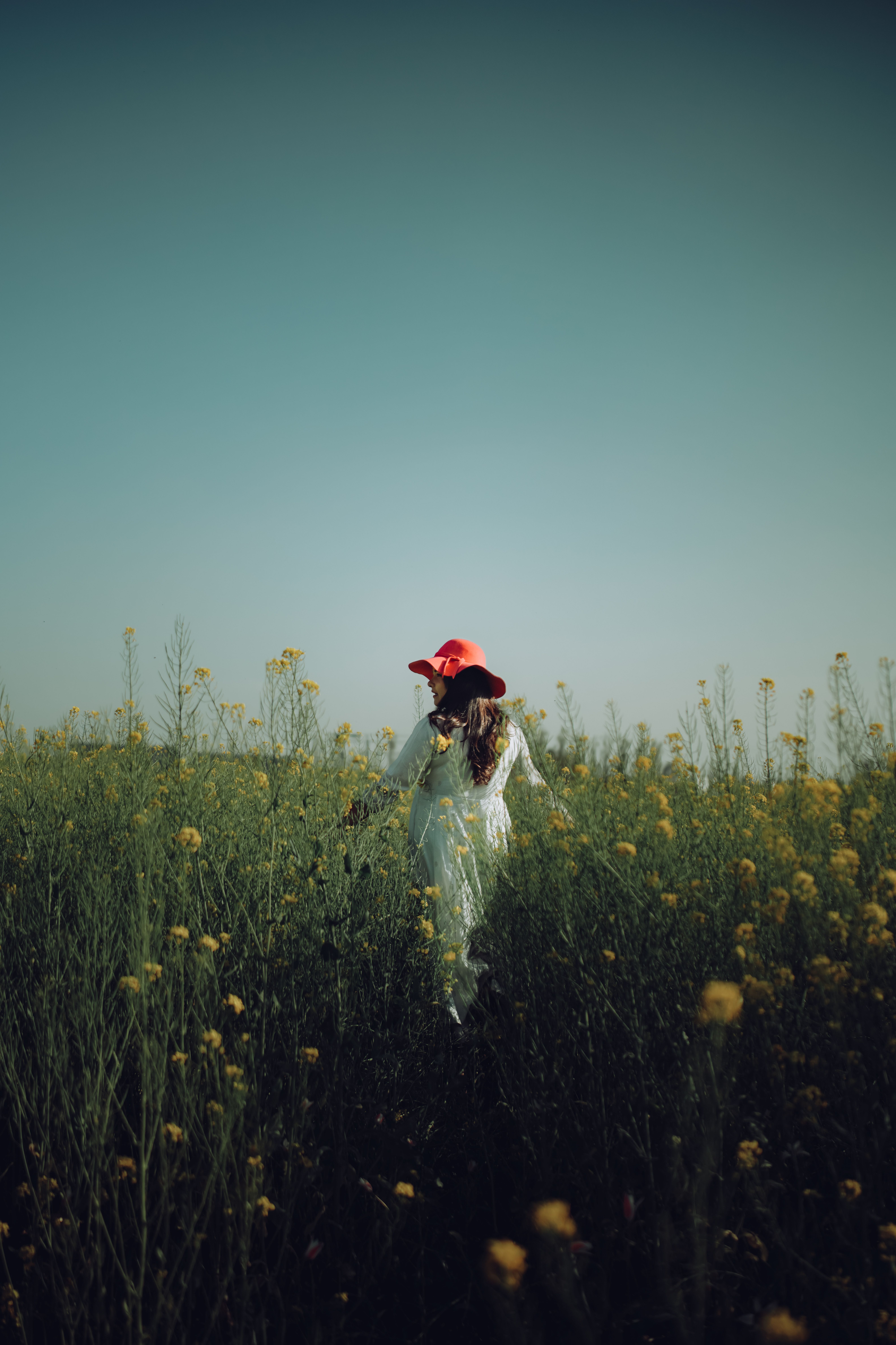 A Woman Wearing a Red Hat Walking on the Field · Free Stock Photo