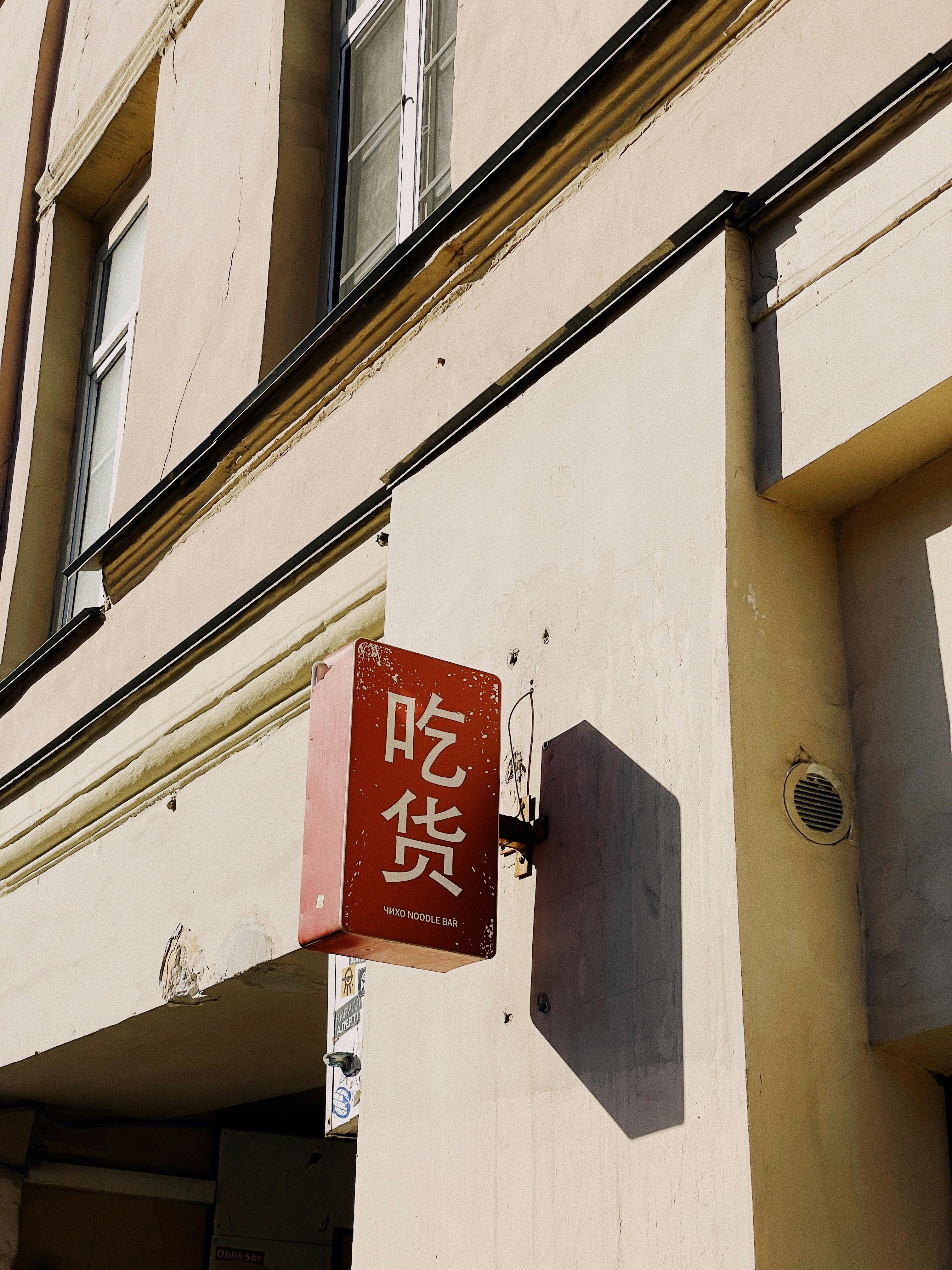 Red Signage mounted on a Building · Free Stock Photo