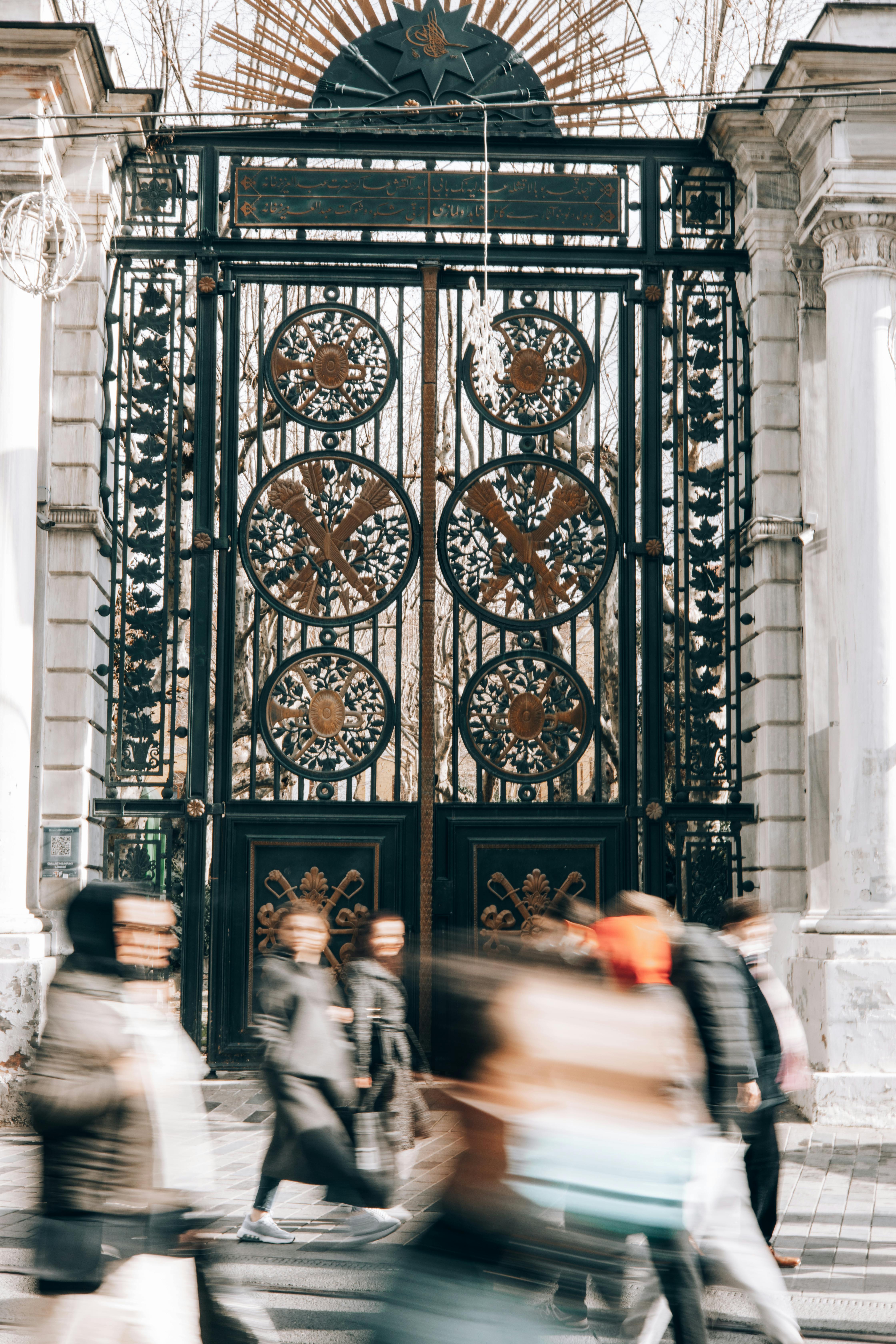 People Walking near Gate in City · Free Stock Photo