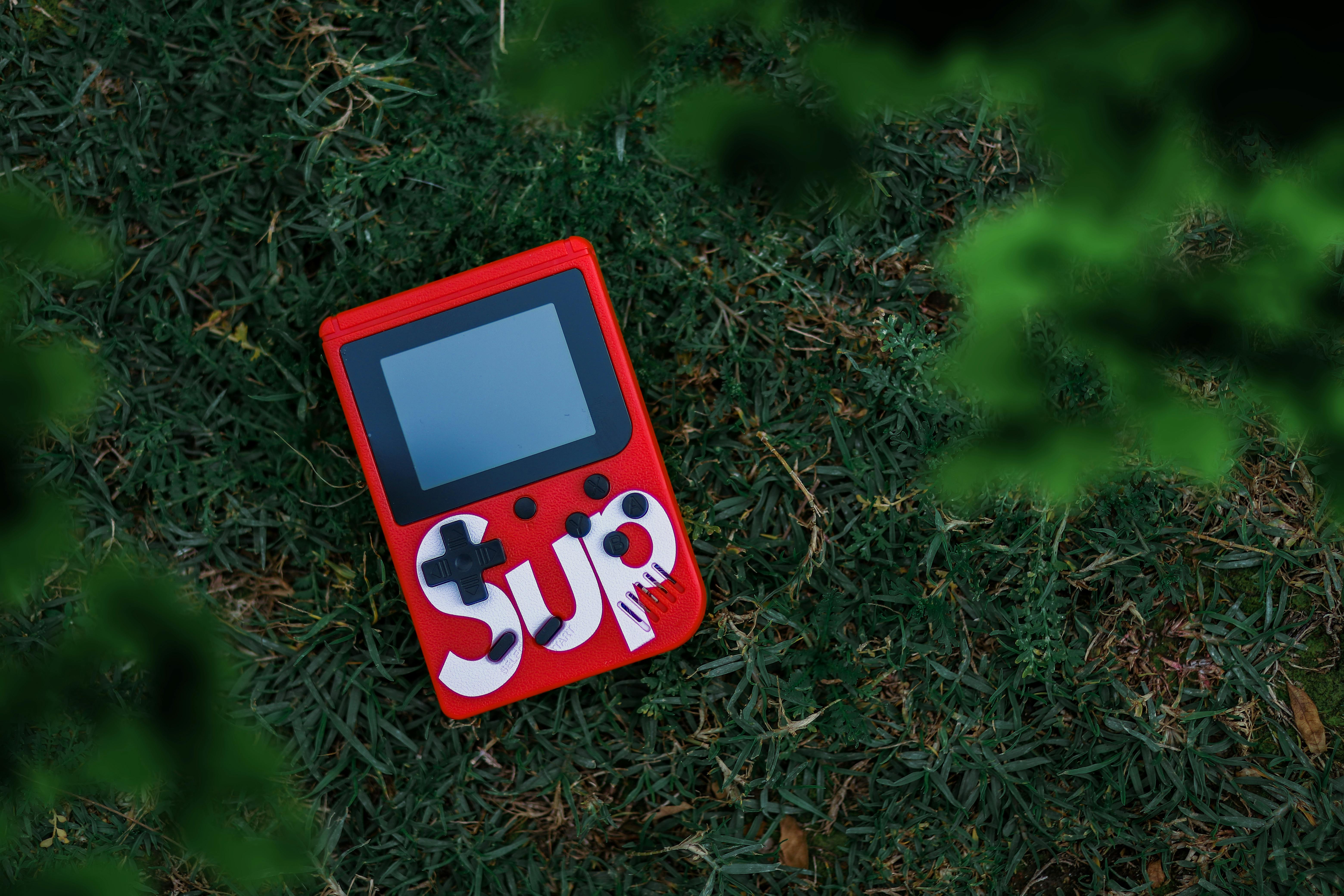 Red Game Boy on the Green Grass · Free Stock Photo