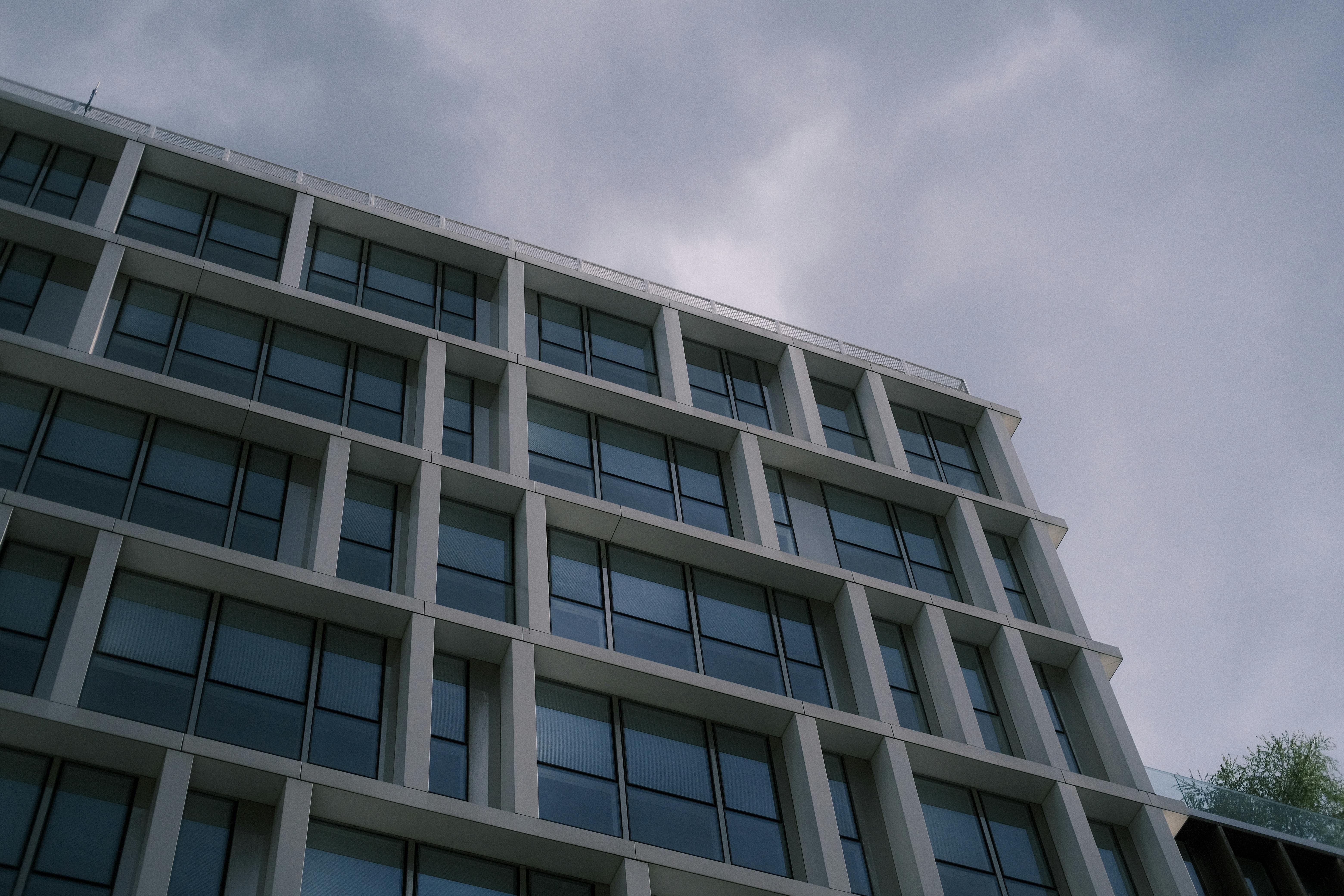 A Low Angle Shot of a Building with Glass Windows Under the White ...