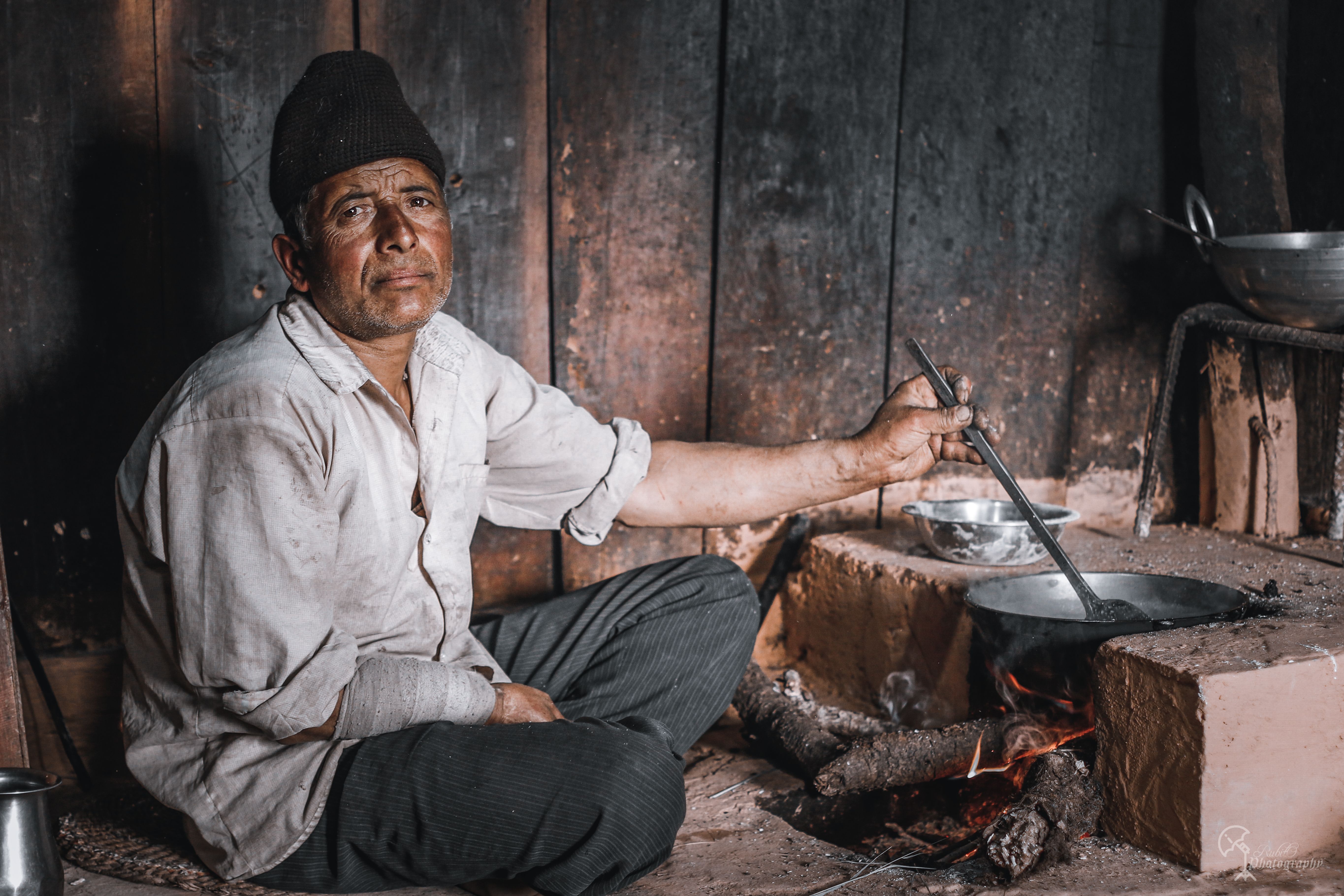 Elderly Man Cooking Over Fire on a Makeshift Stove · Free Stock Photo