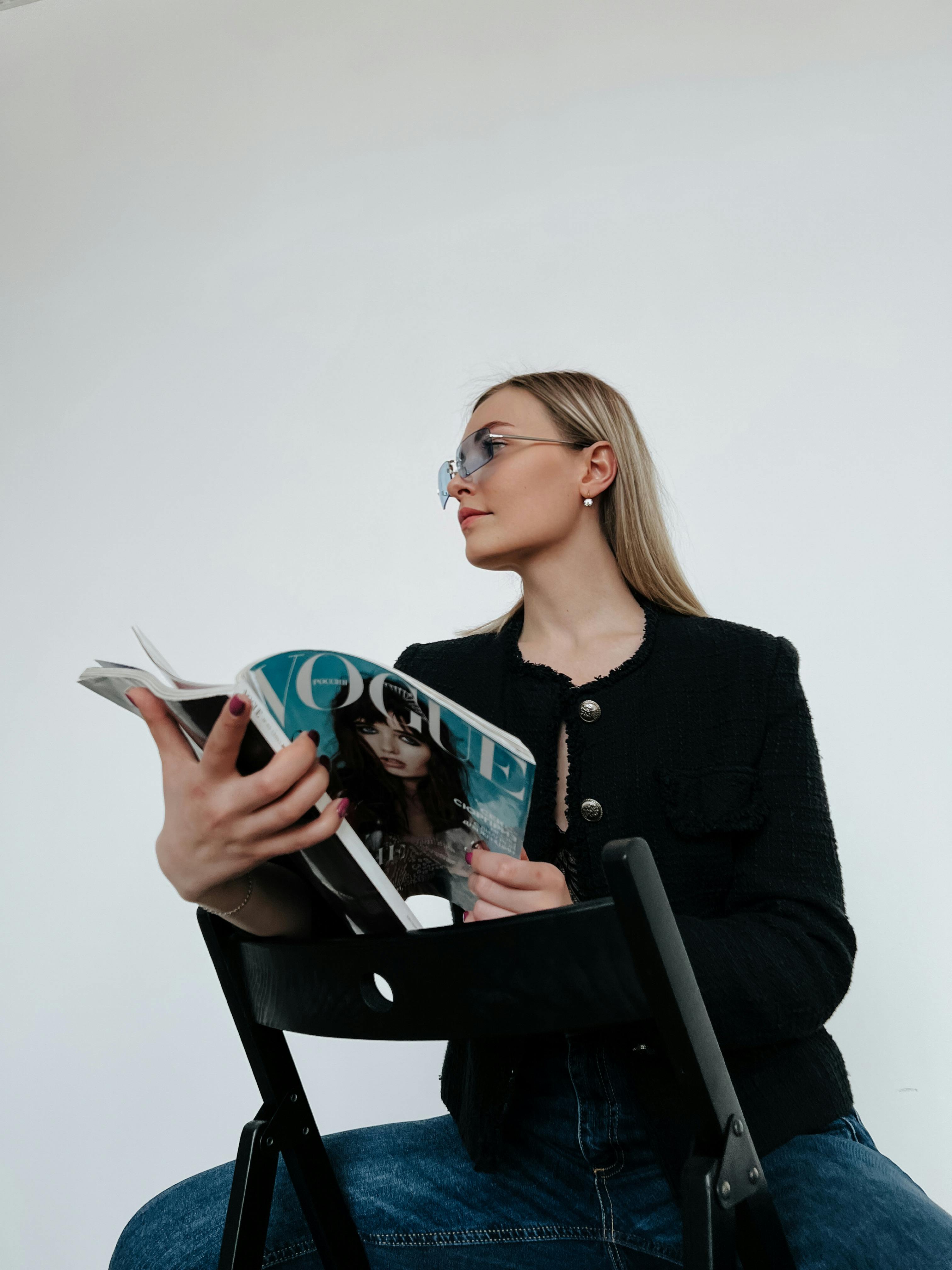 Woman Reading a Vogue Magazine while Sitting on a Couch · Free Stock Photo