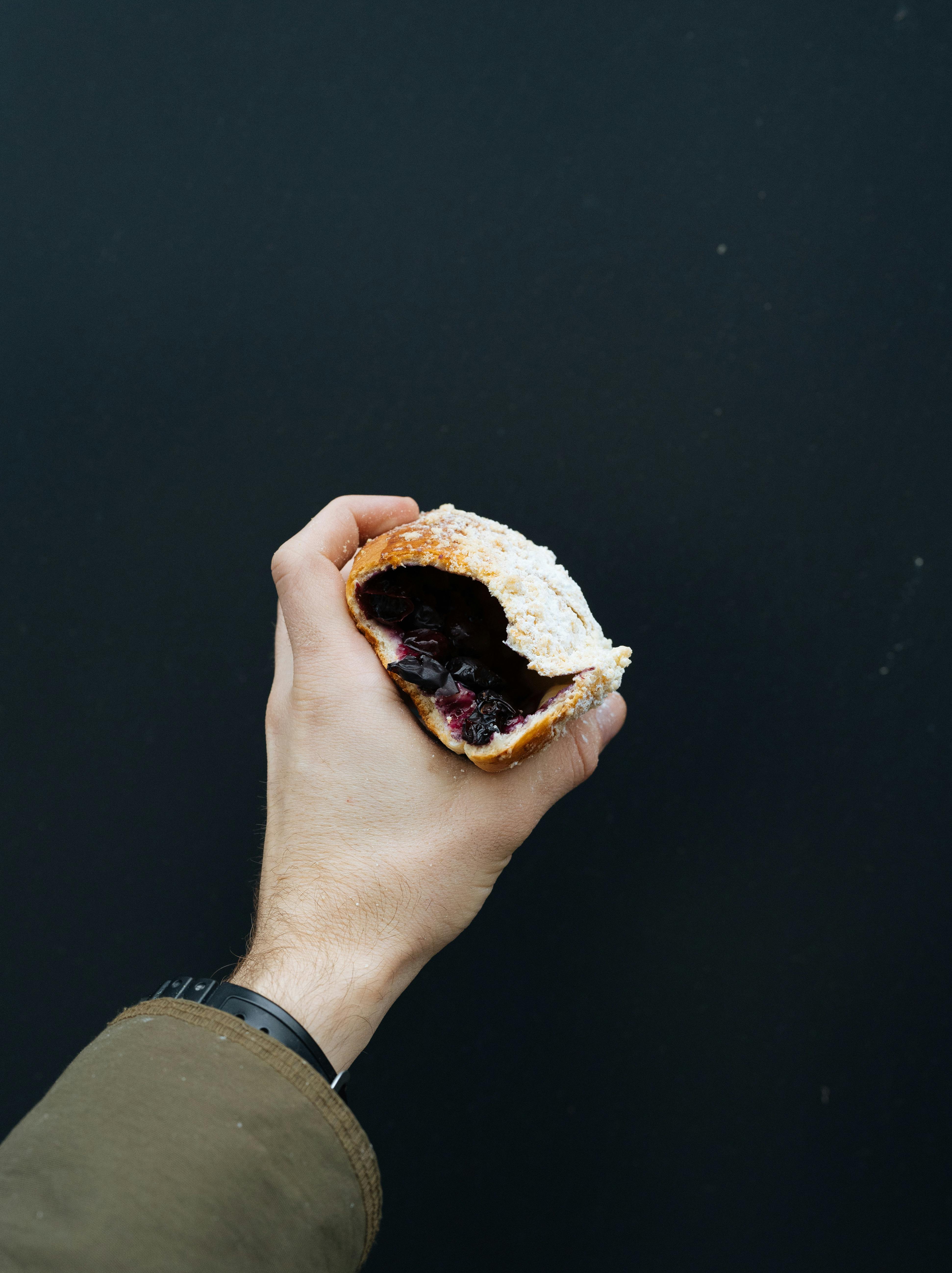 A Person Holding a Bread with Filling · Free Stock Photo