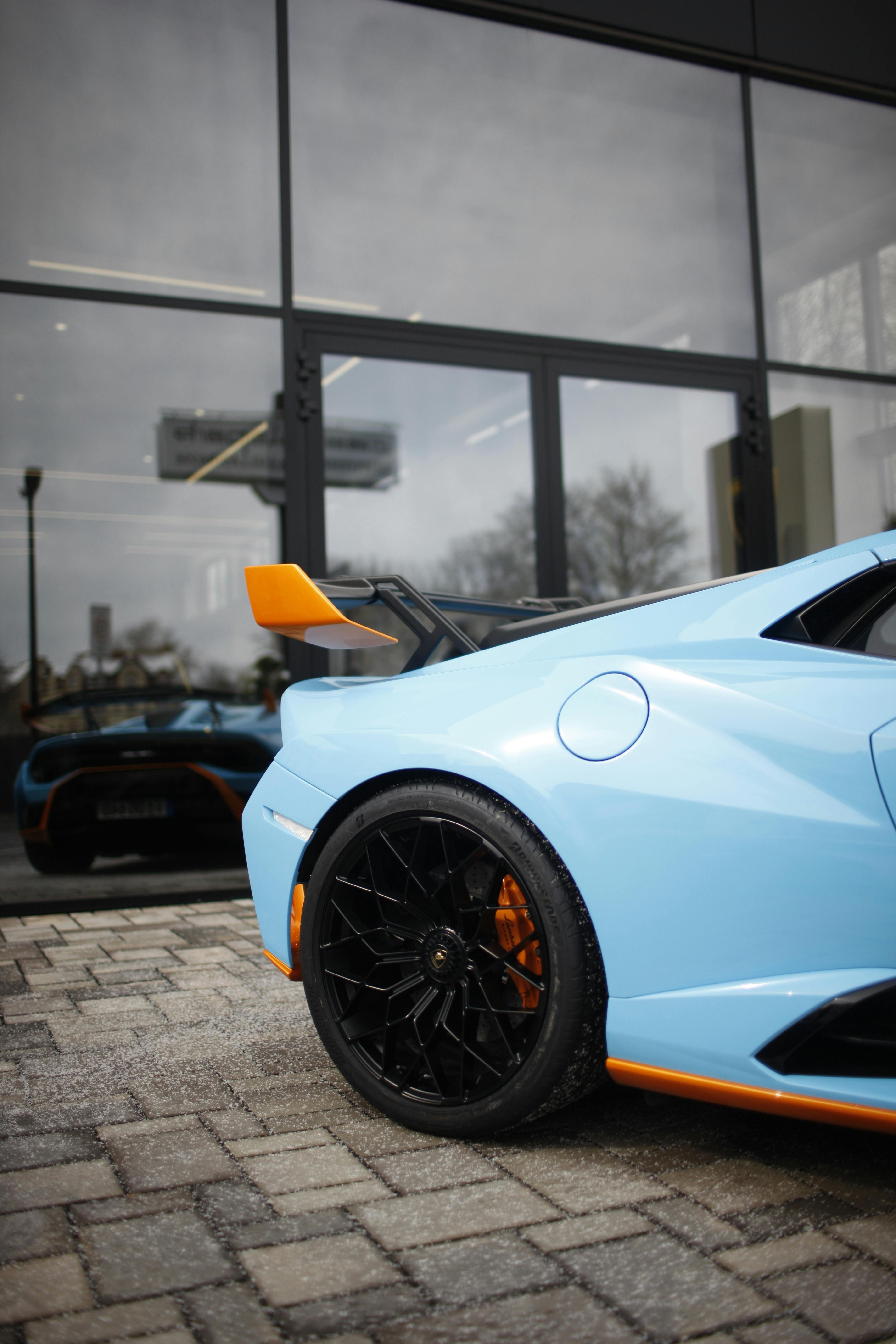 Light Blue Sports Car with Reflection on Glass · Free Stock Photo
