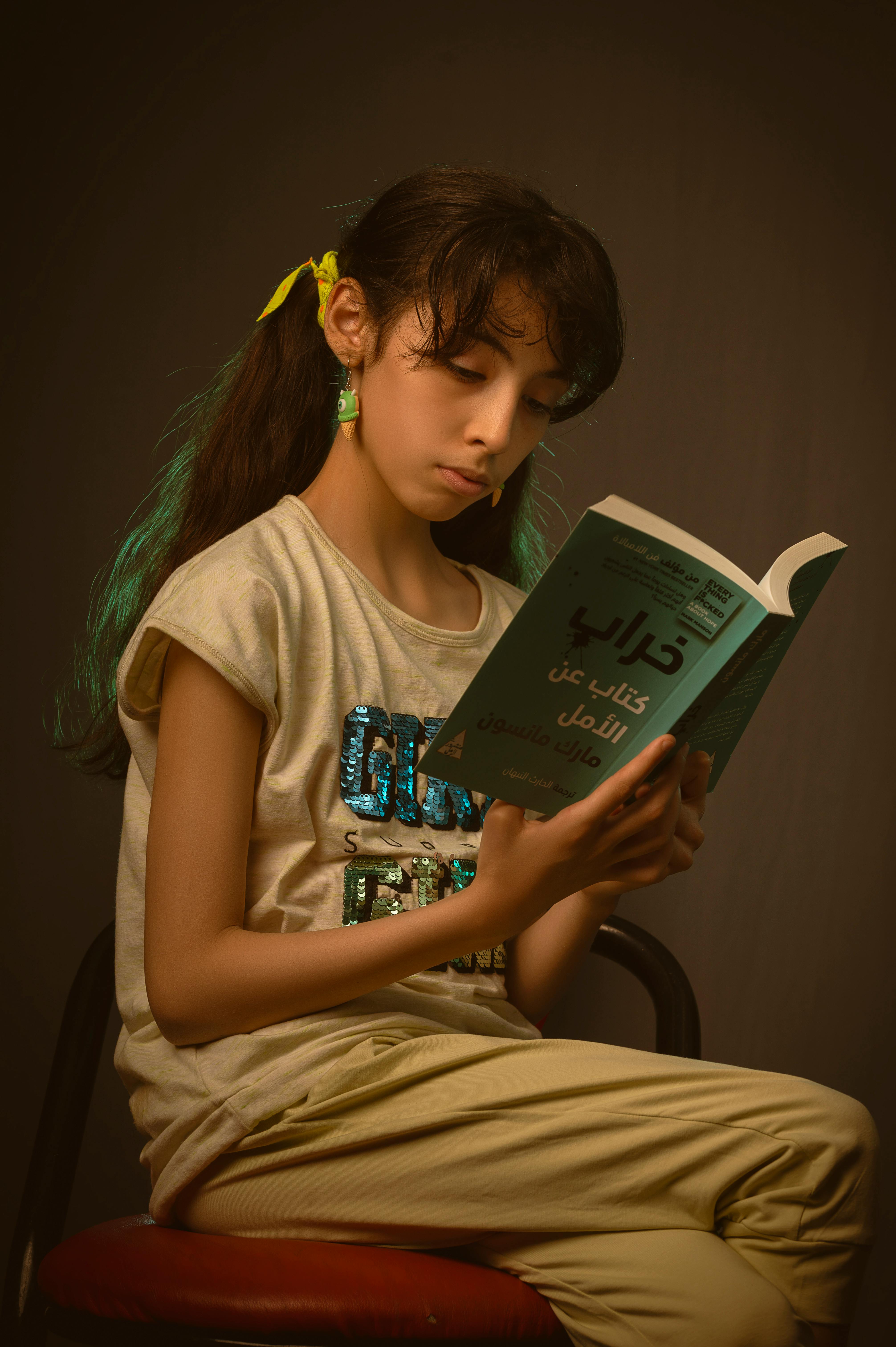 Girl Sitting on Chair While Reading a Book · Free Stock Photo
