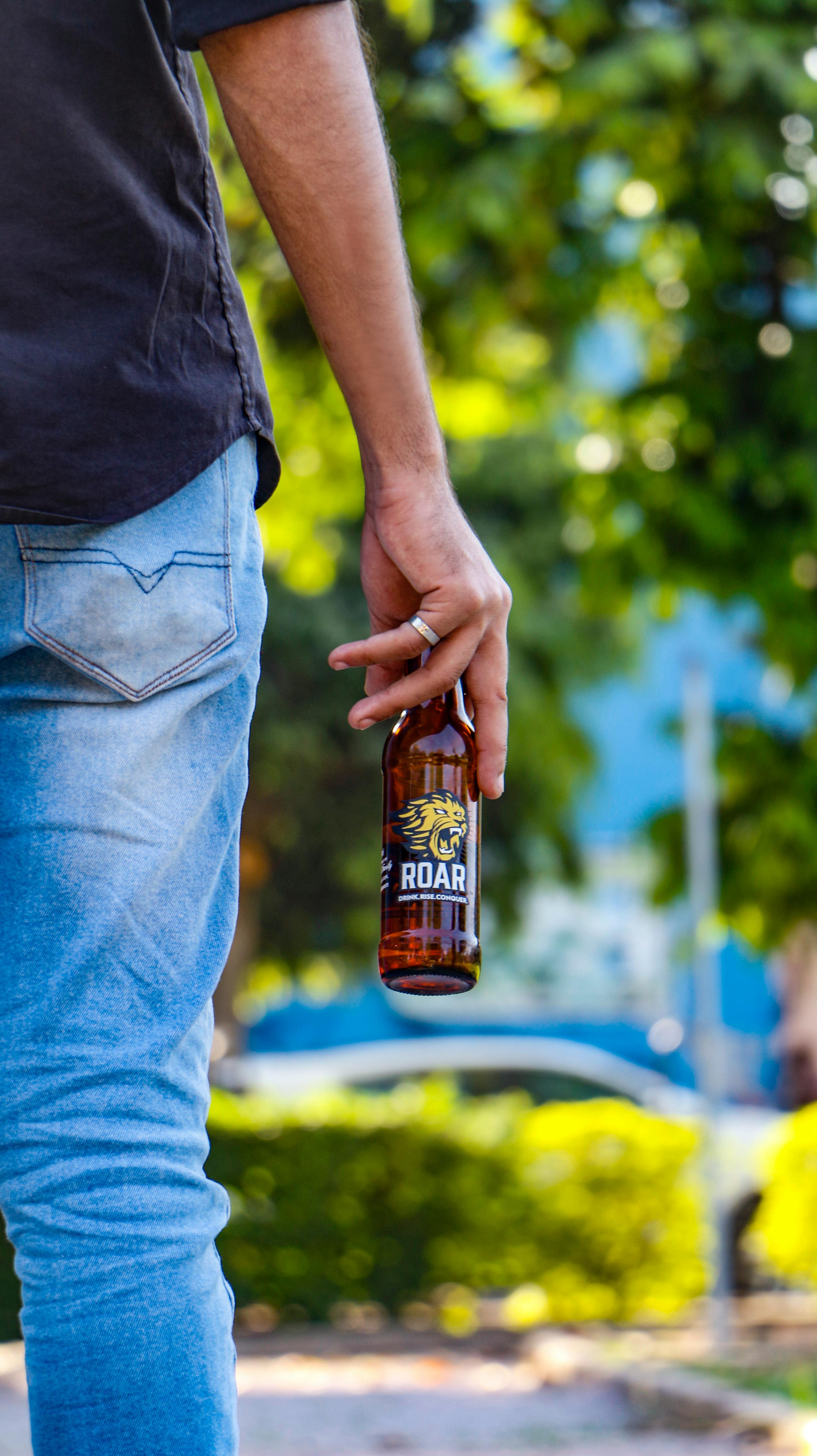 A Man Holding a Bottle of Beer · Free Stock Photo