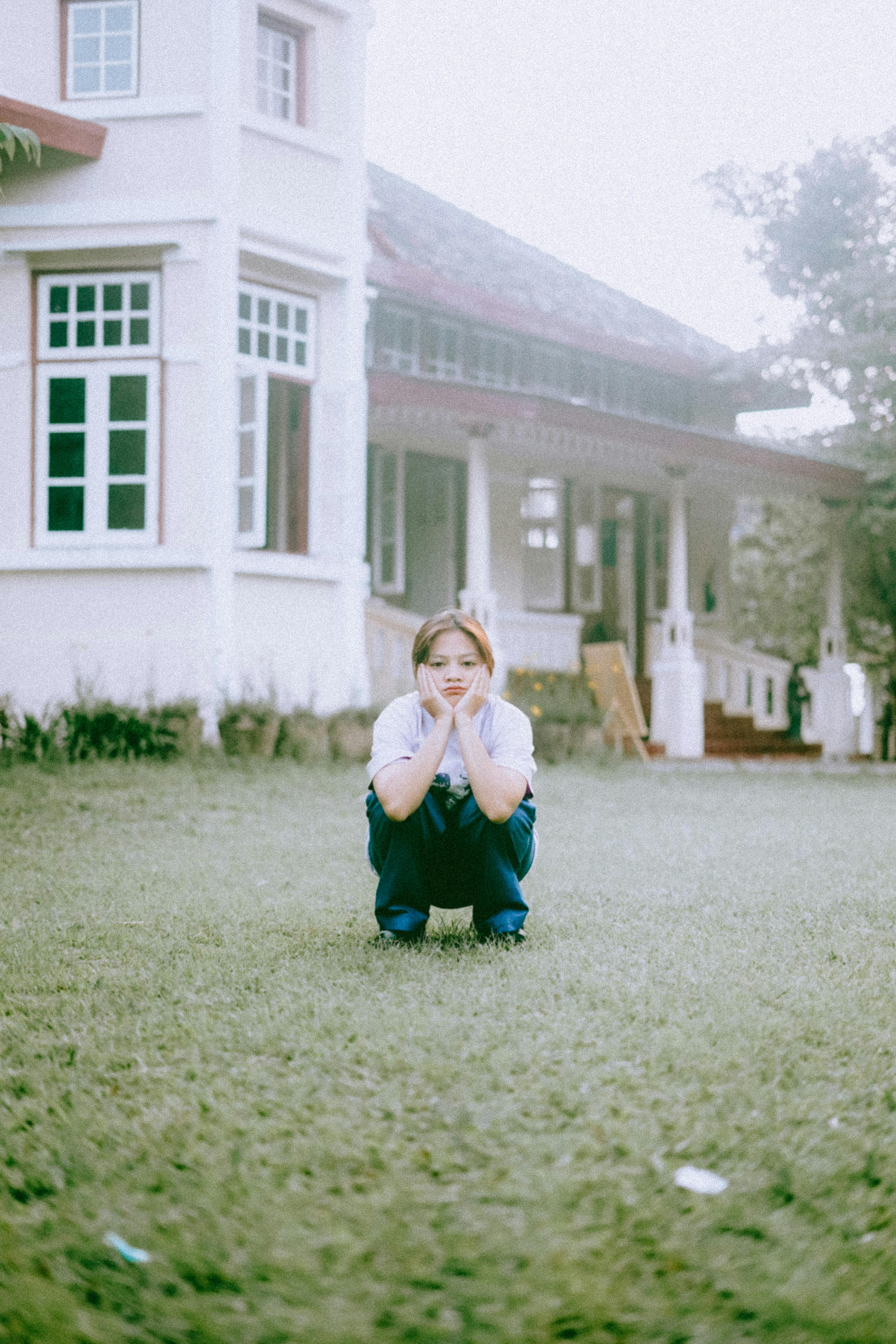 Teenage Girl Crouching on Grass · Free Stock Photo