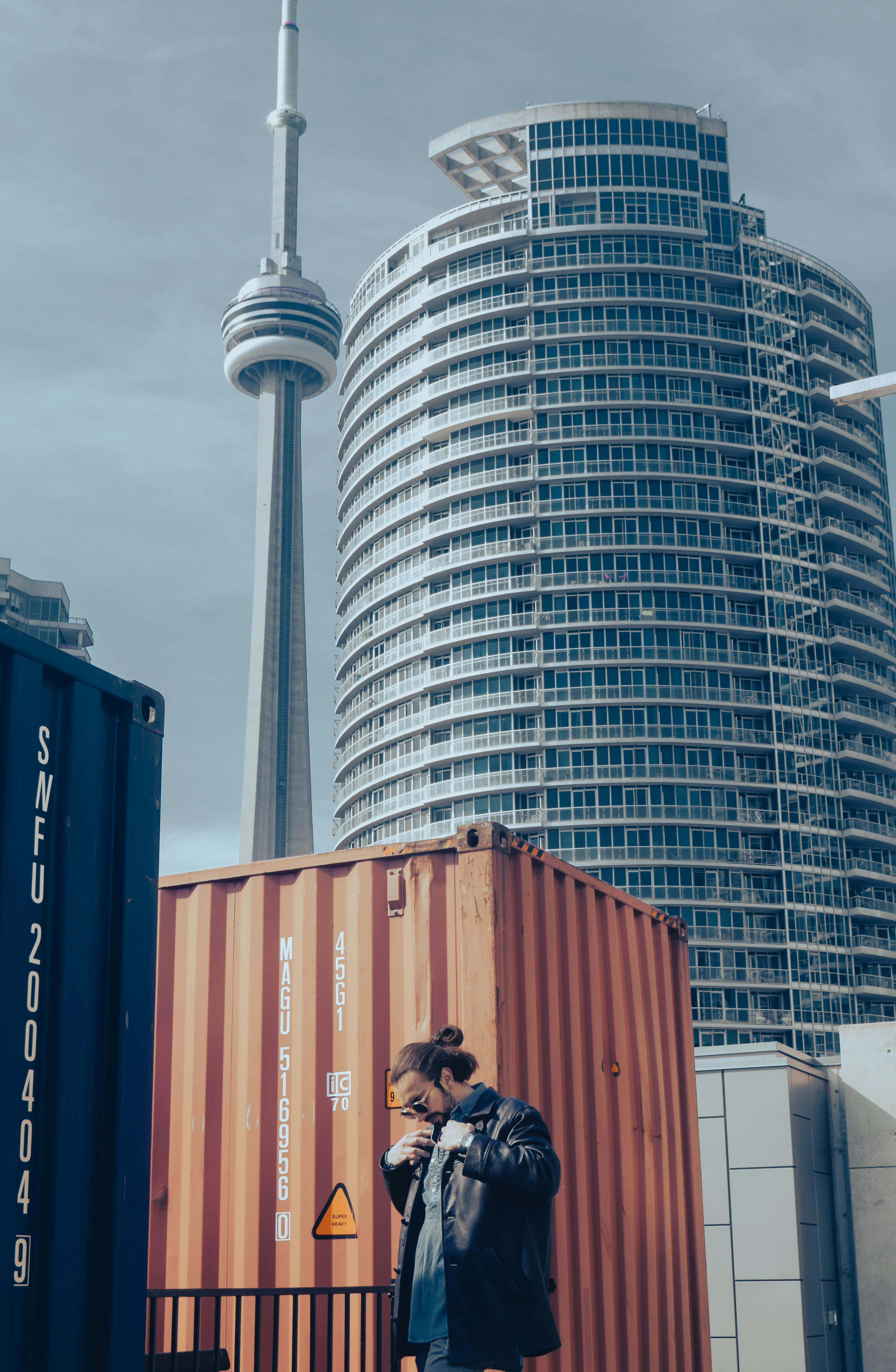 man Standing Beside a Metal Shipping Container · Free Stock Photo