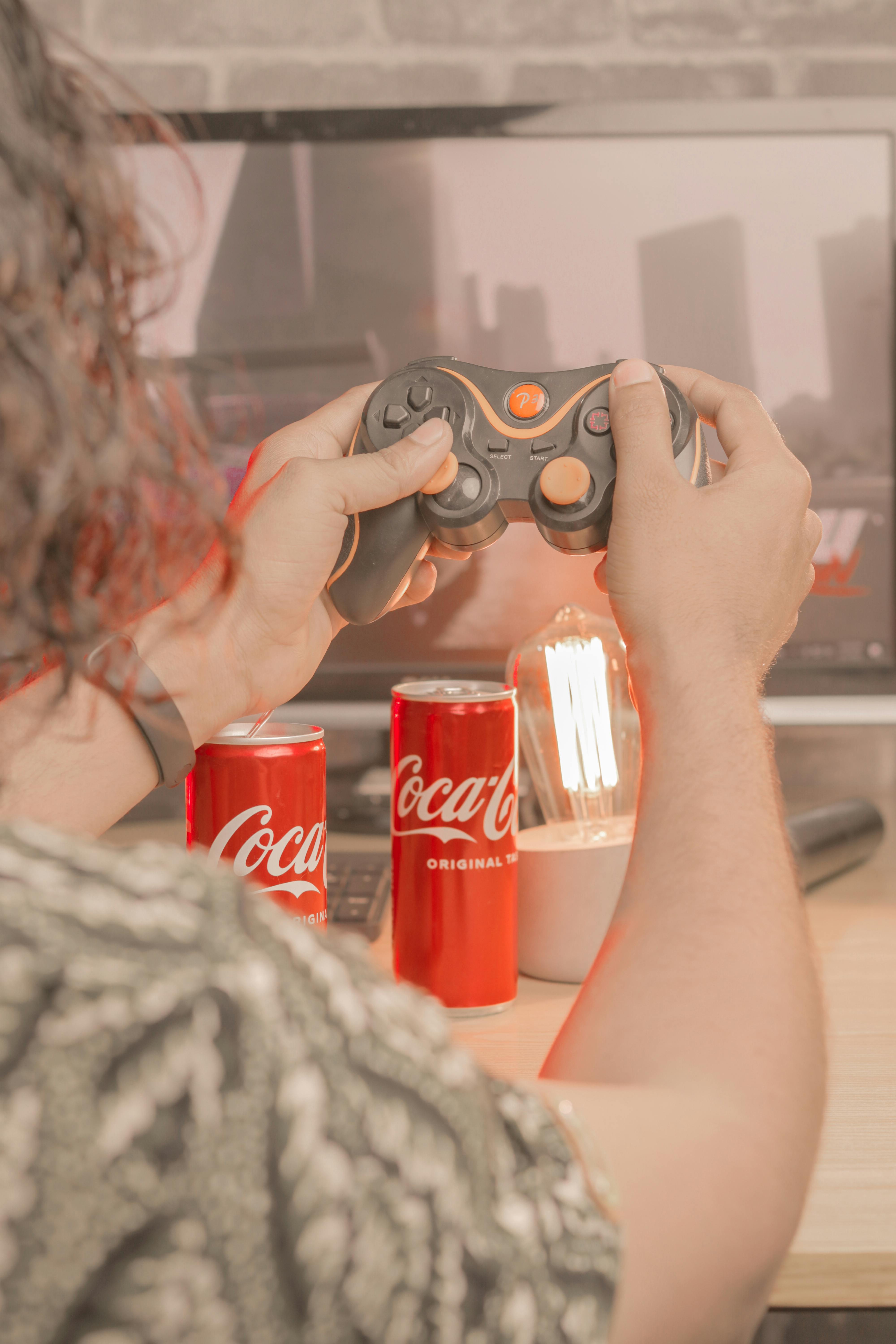 Two People holding Black Gaming Consoles · Free Stock Photo