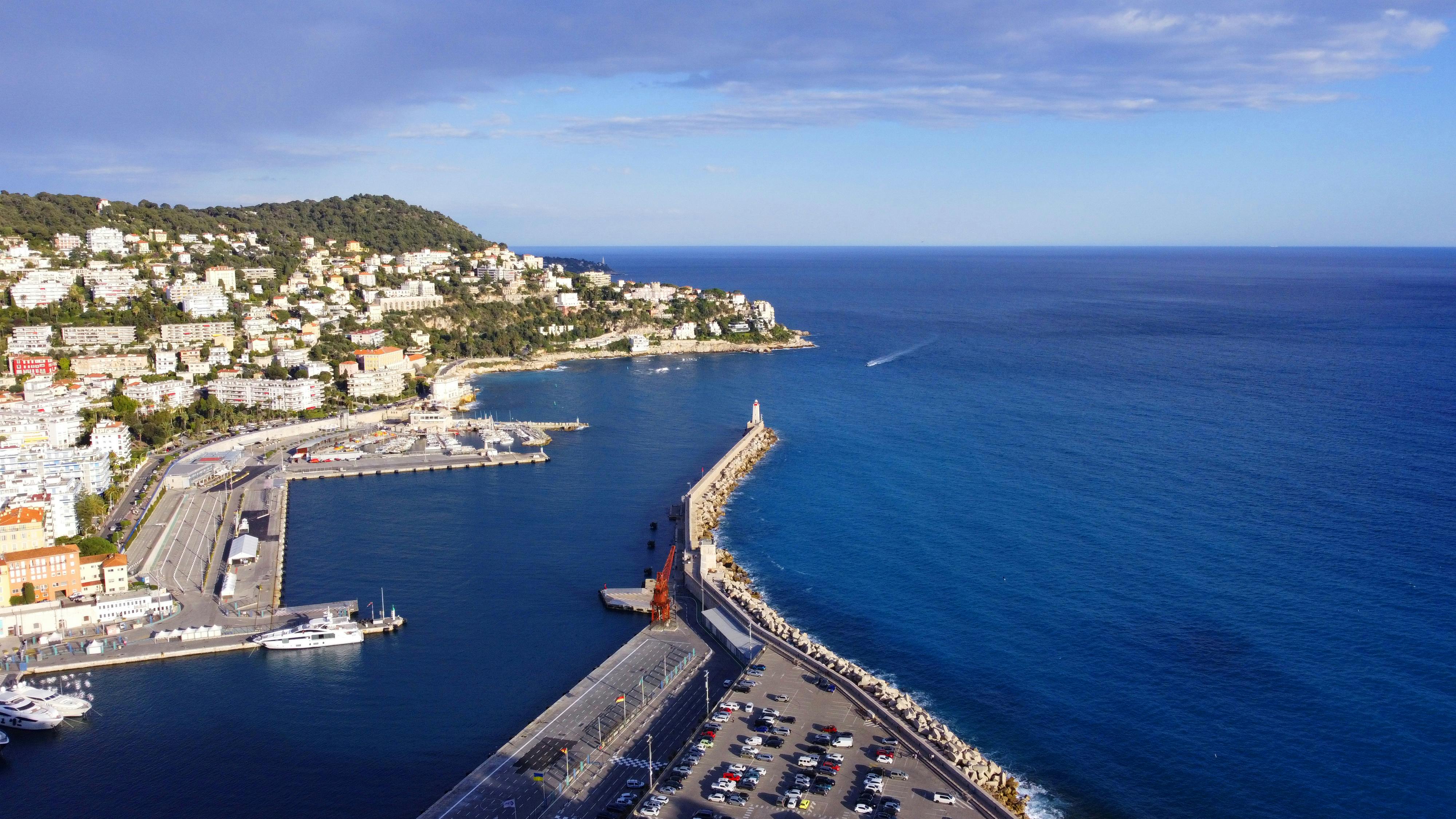 Red Concrete Building Near the Ocean With Boat during Daytime · Free ...