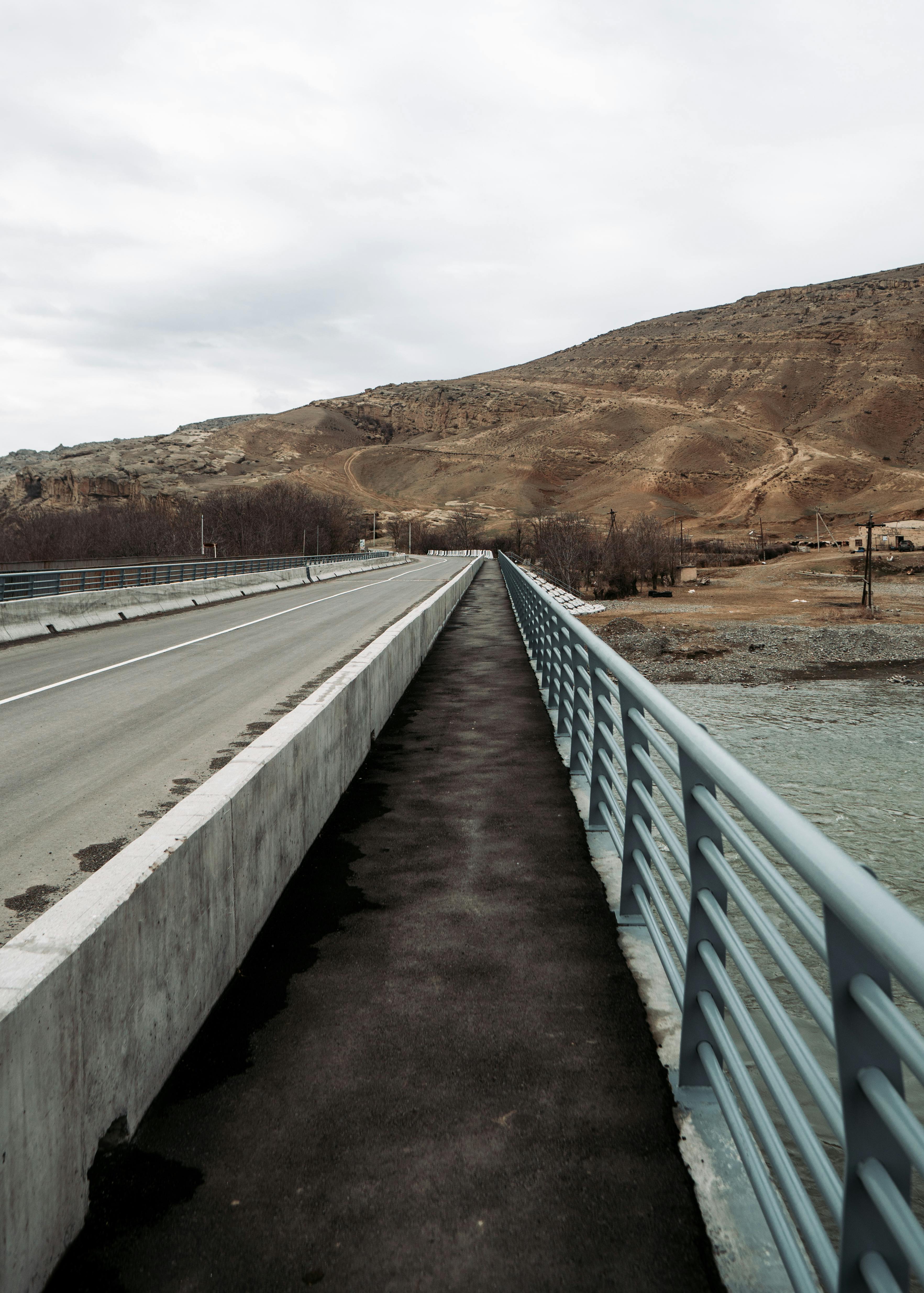 Sidewalk on the Bridge Separated from the Road by a Concrete Barrier ...