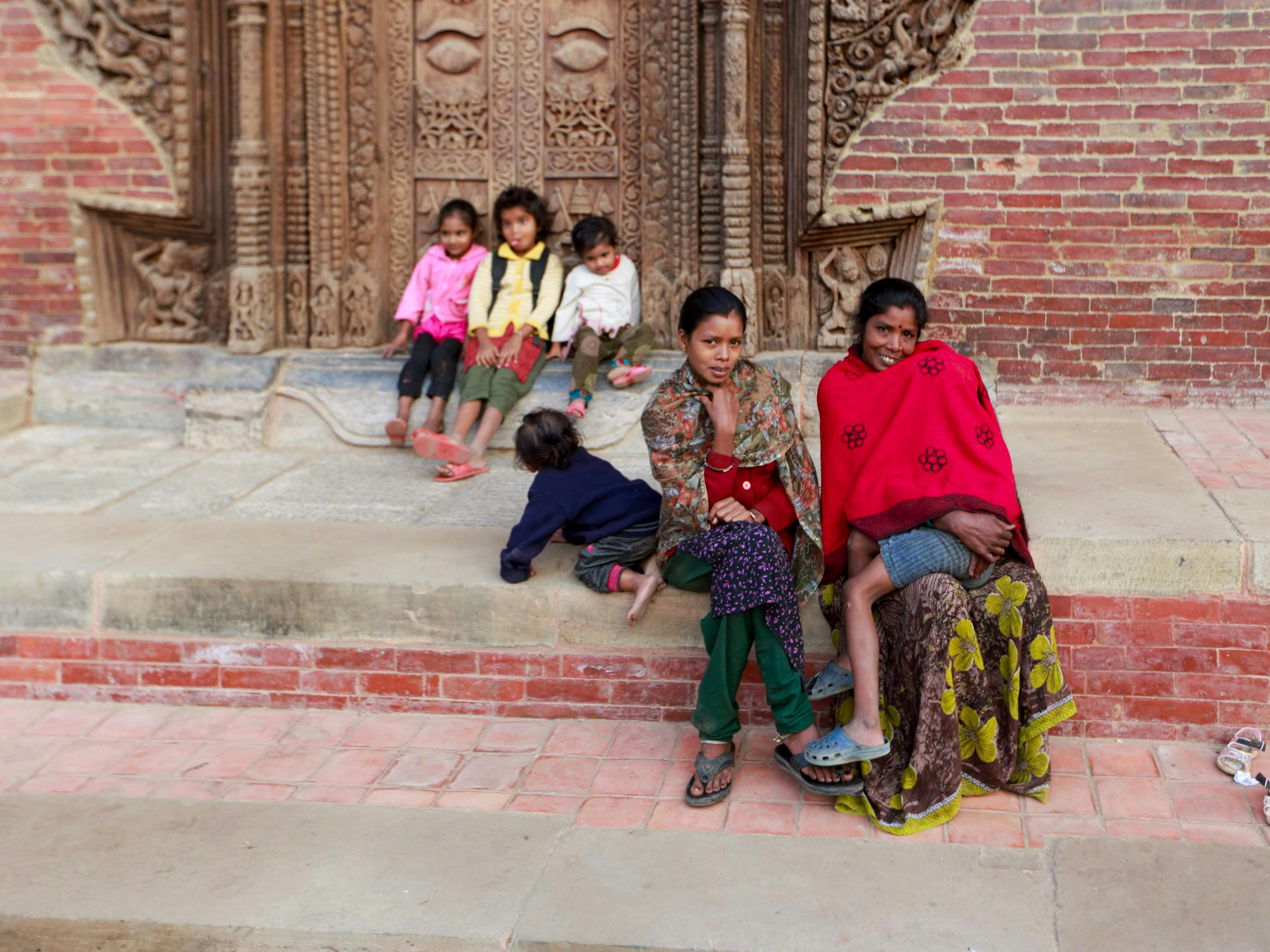 Group of Happy People Sitting on a Pavement · Free Stock Photo