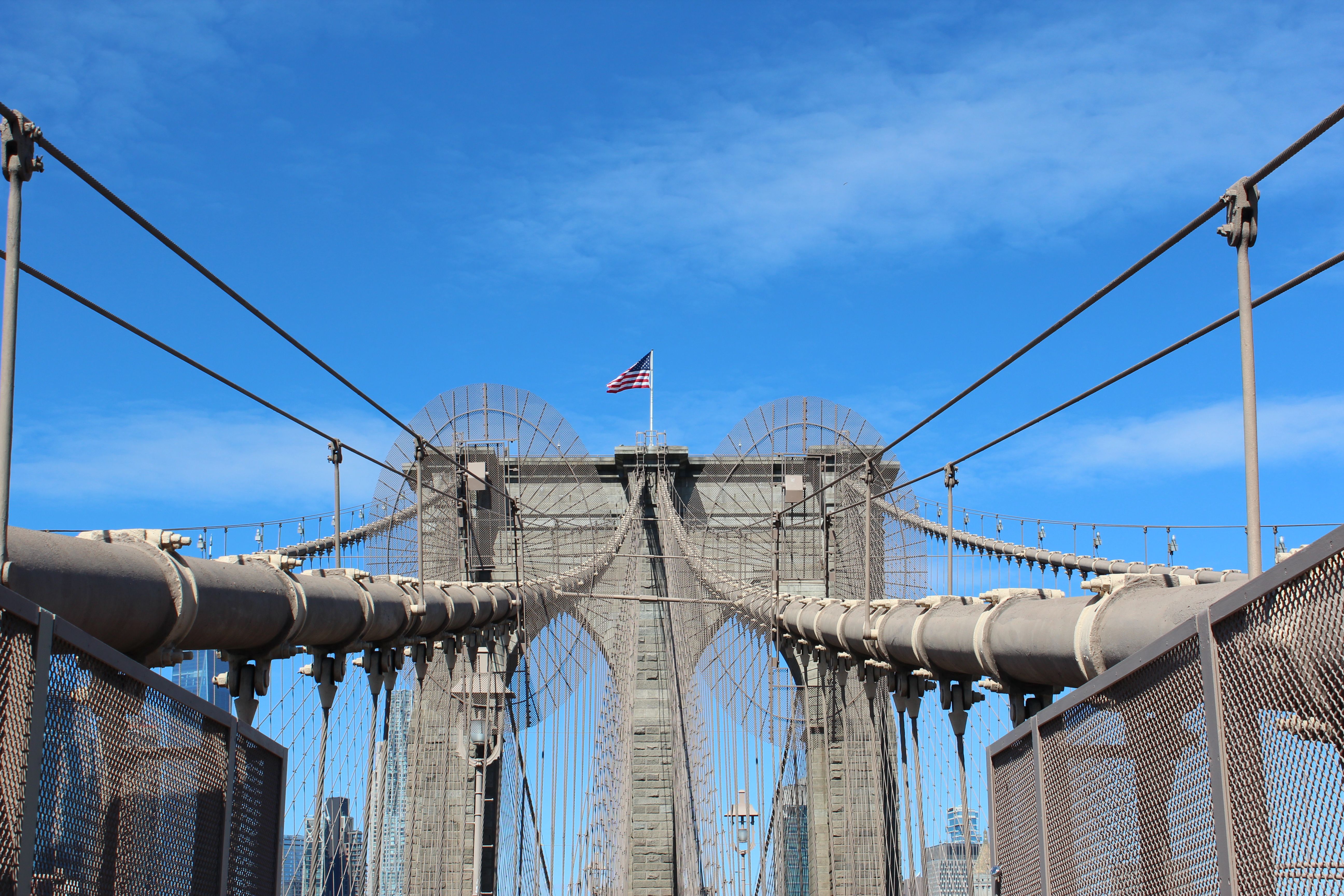 American Flag on a Gray Metal Bridge Under Blue Sky · Free Stock Photo