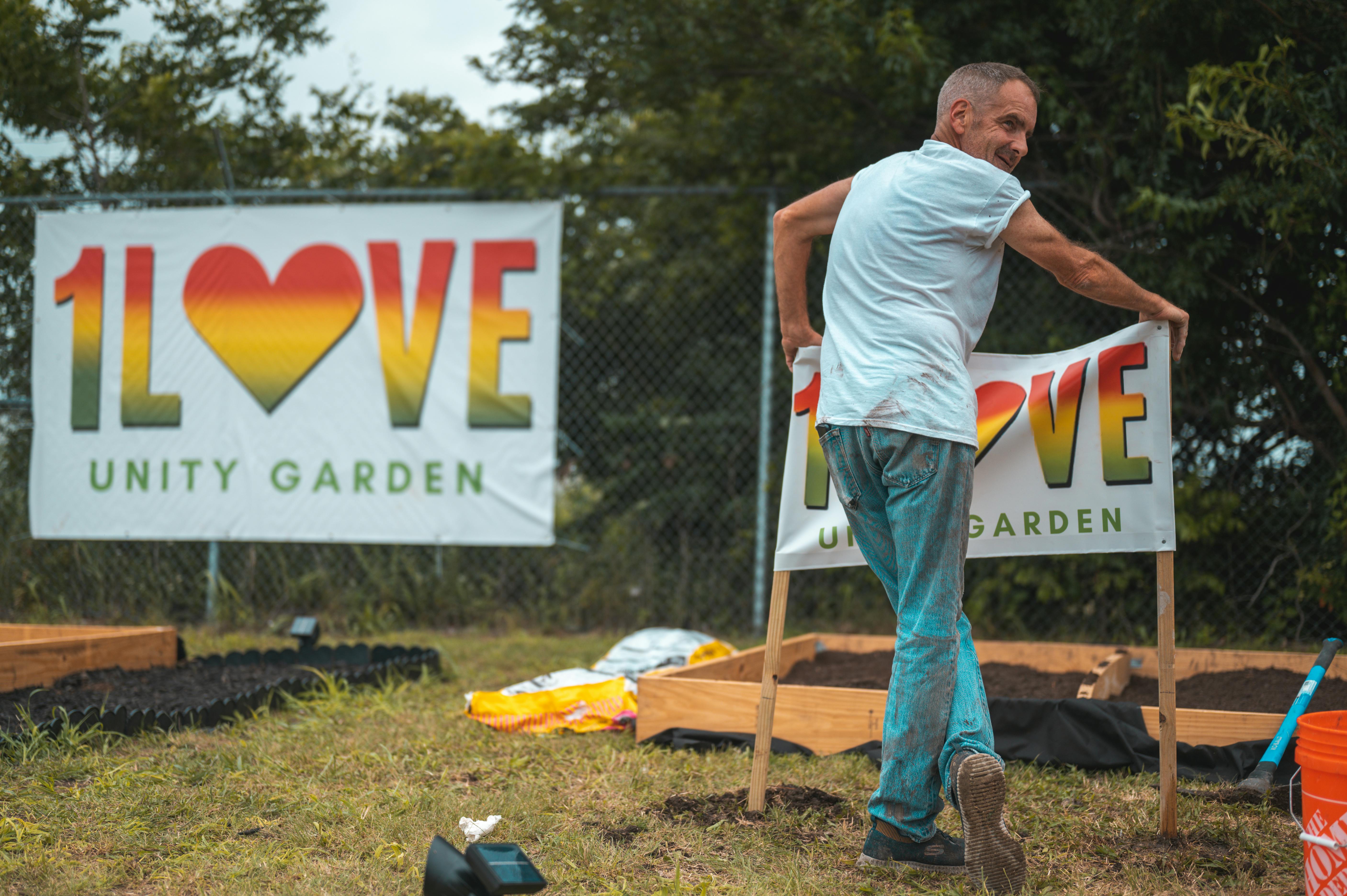 A Man Putting Up Poster in the Garden · Free Stock Photo