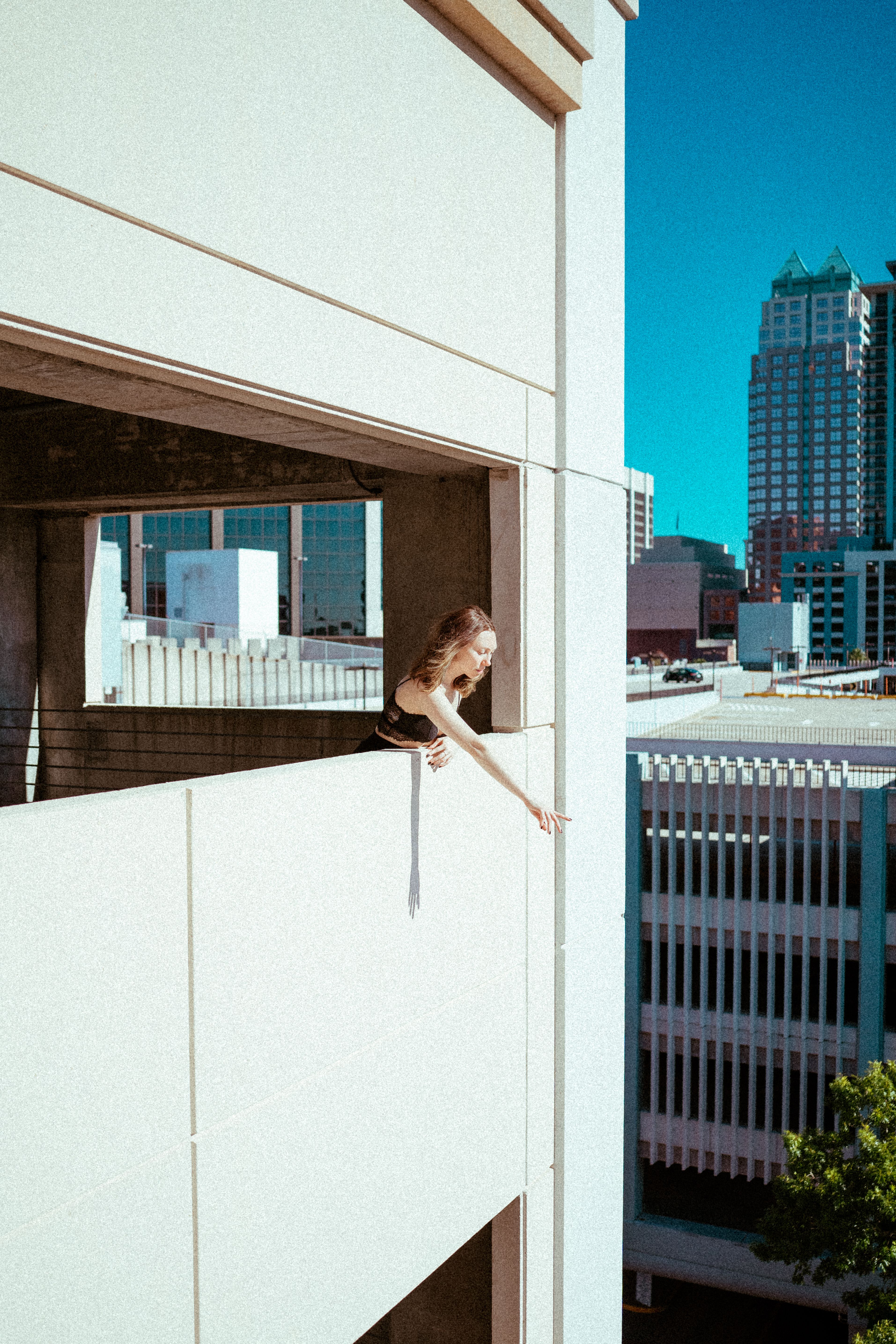 Woman Leaning Out of Window in City · Free Stock Photo