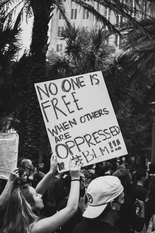 Grayscale Photo of a Protester Holding Placard · Free Stock Photo Grayscale Photo of a Protester Holding Placard · Free Stock Photo