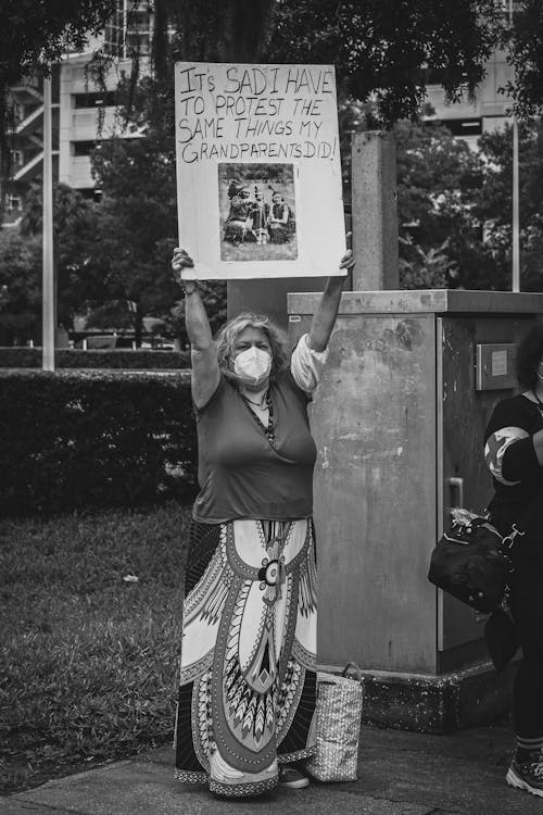 Grayscale Photo of a Protester Holding Placard · Free Stock Photo Grayscale Photo of a Protester Holding Placard · Free Stock Photo