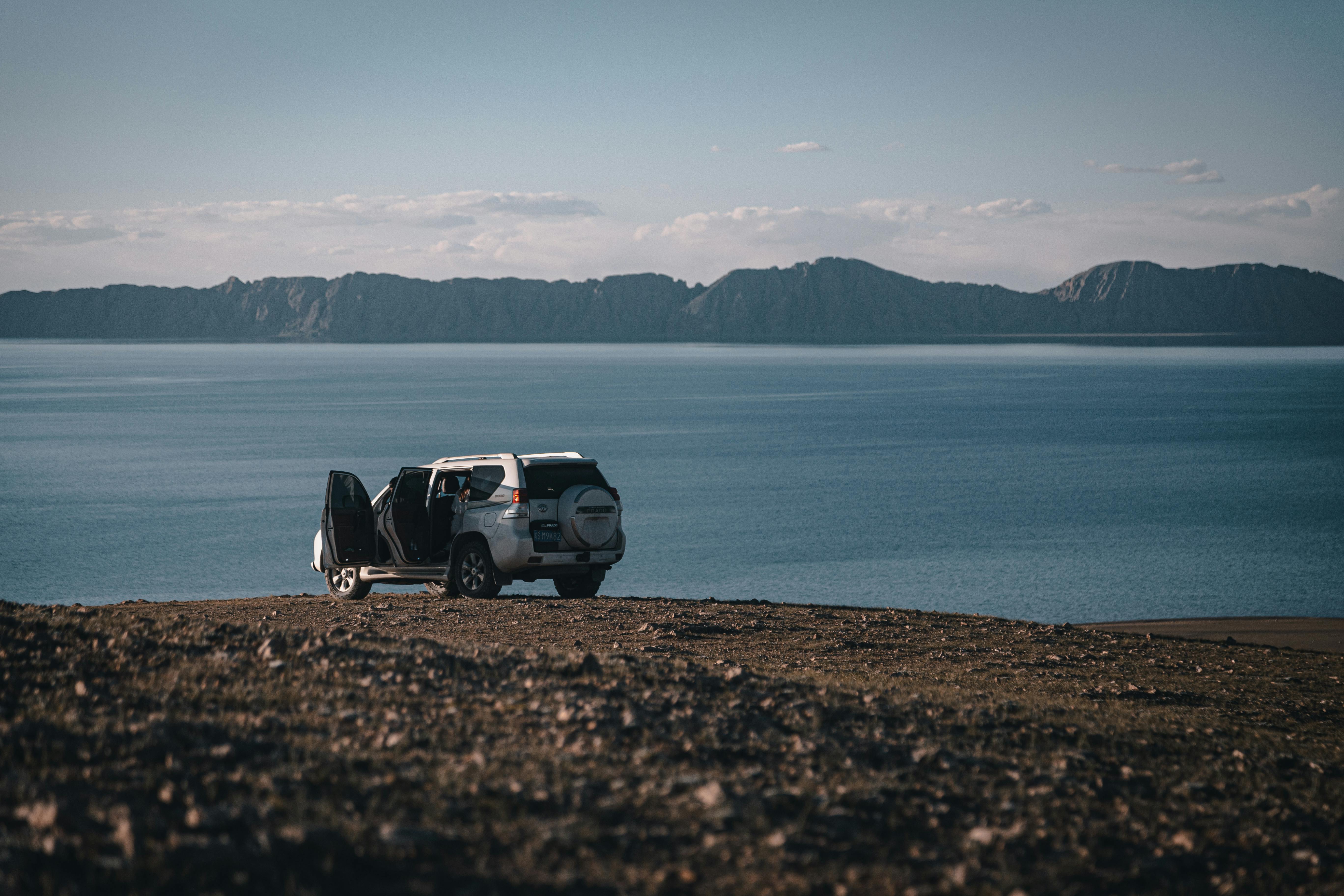 Suv Vehicle Parked by the Lake · Free Stock Photo