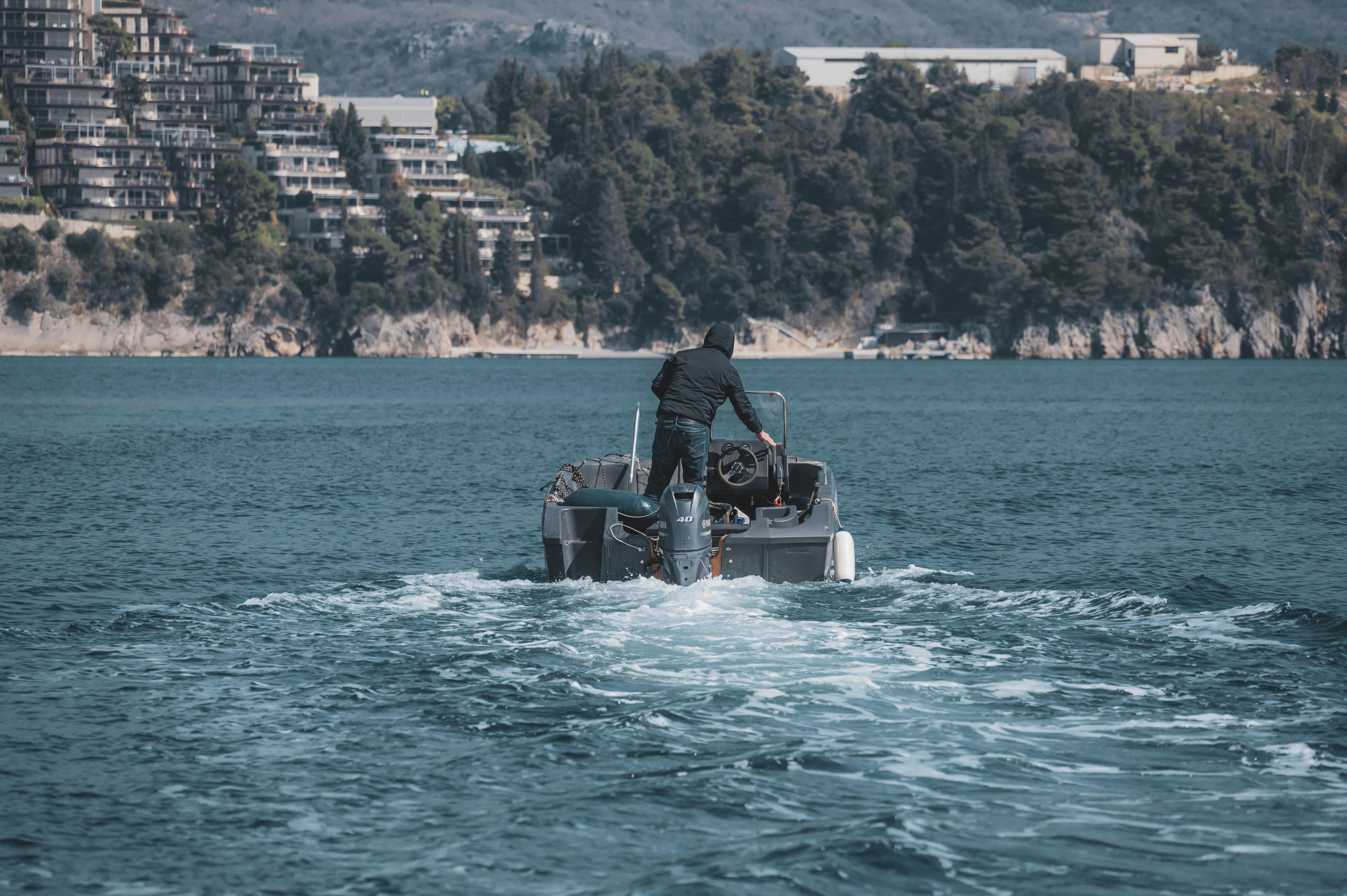 Man Steering Motorboat by Shore · Free Stock Photo