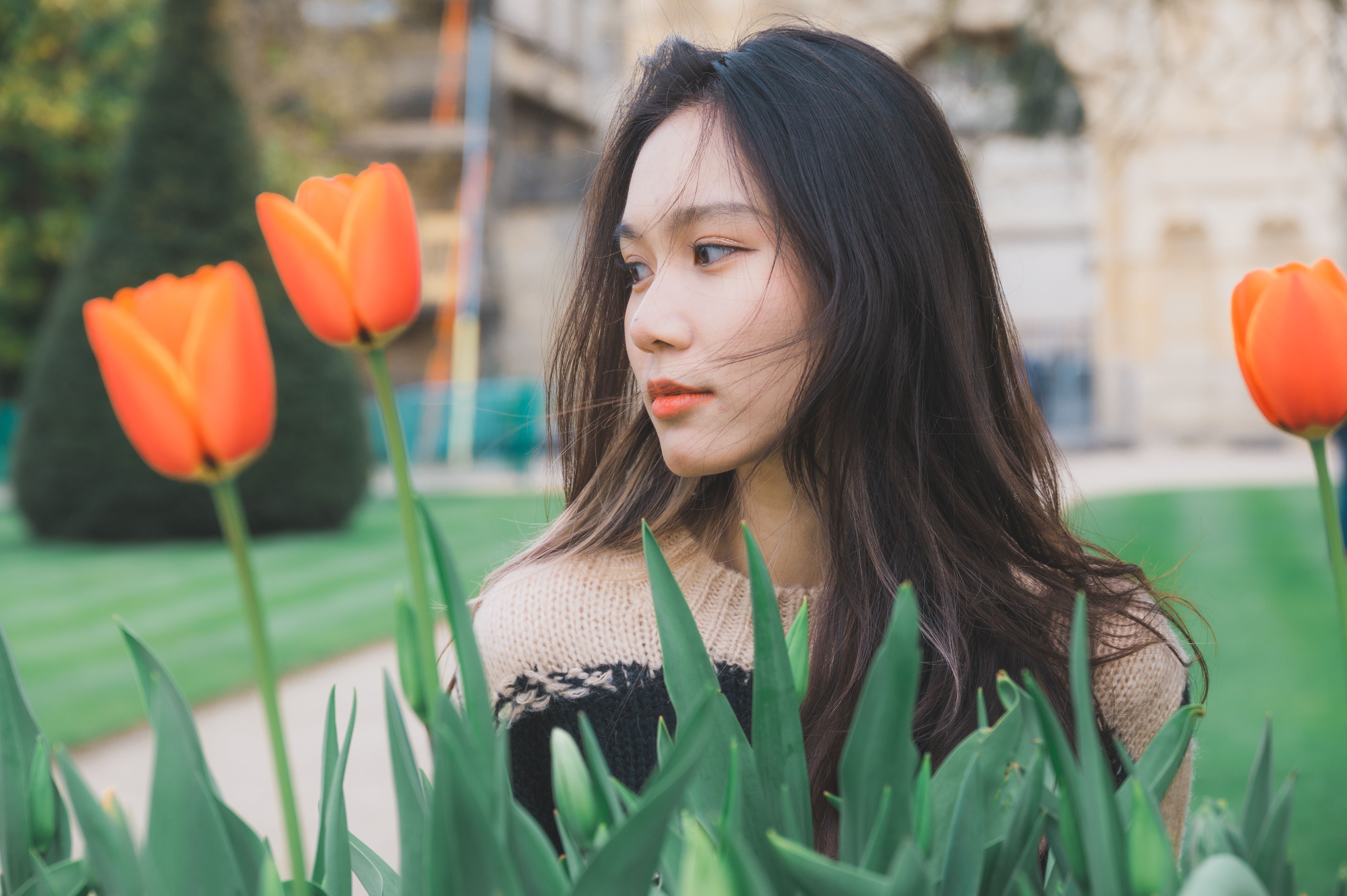 Portrait of a Woman Standing Behind Flowers · Free Stock Photo
