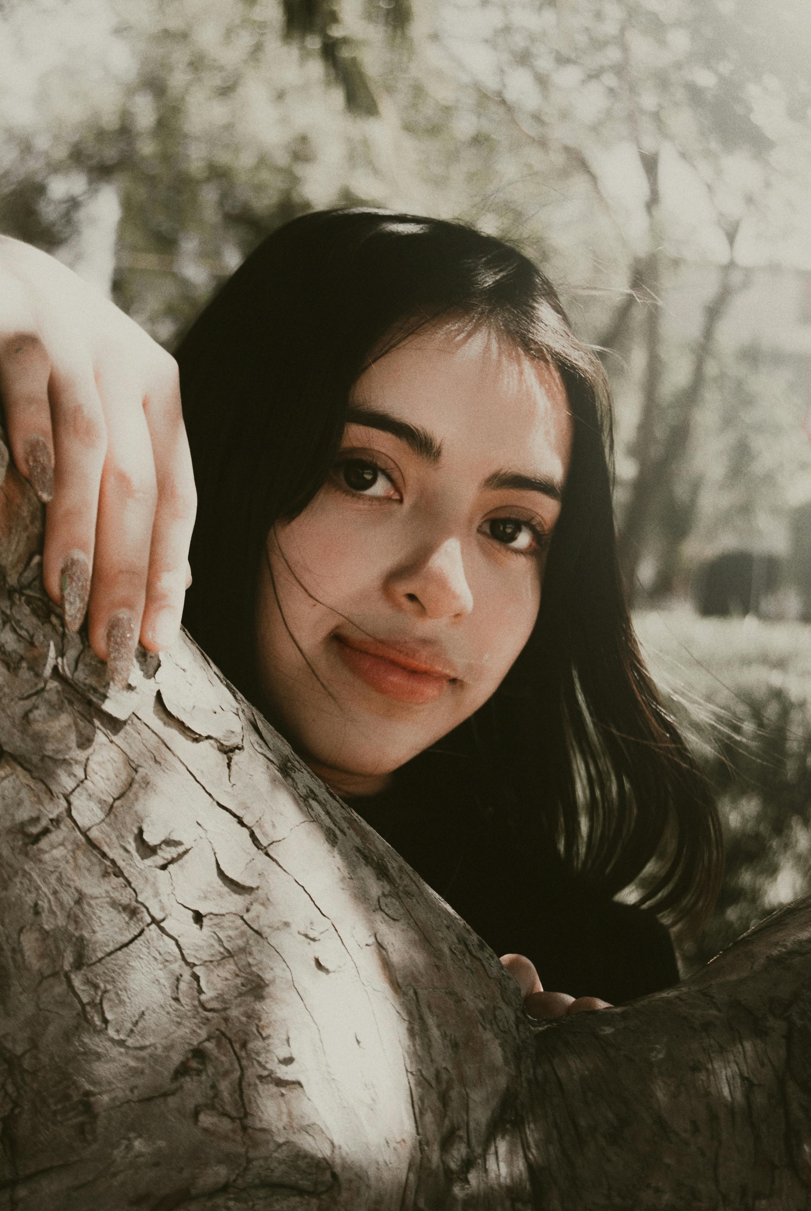A Woman Leaning on Tree Trunk · Free Stock Photo