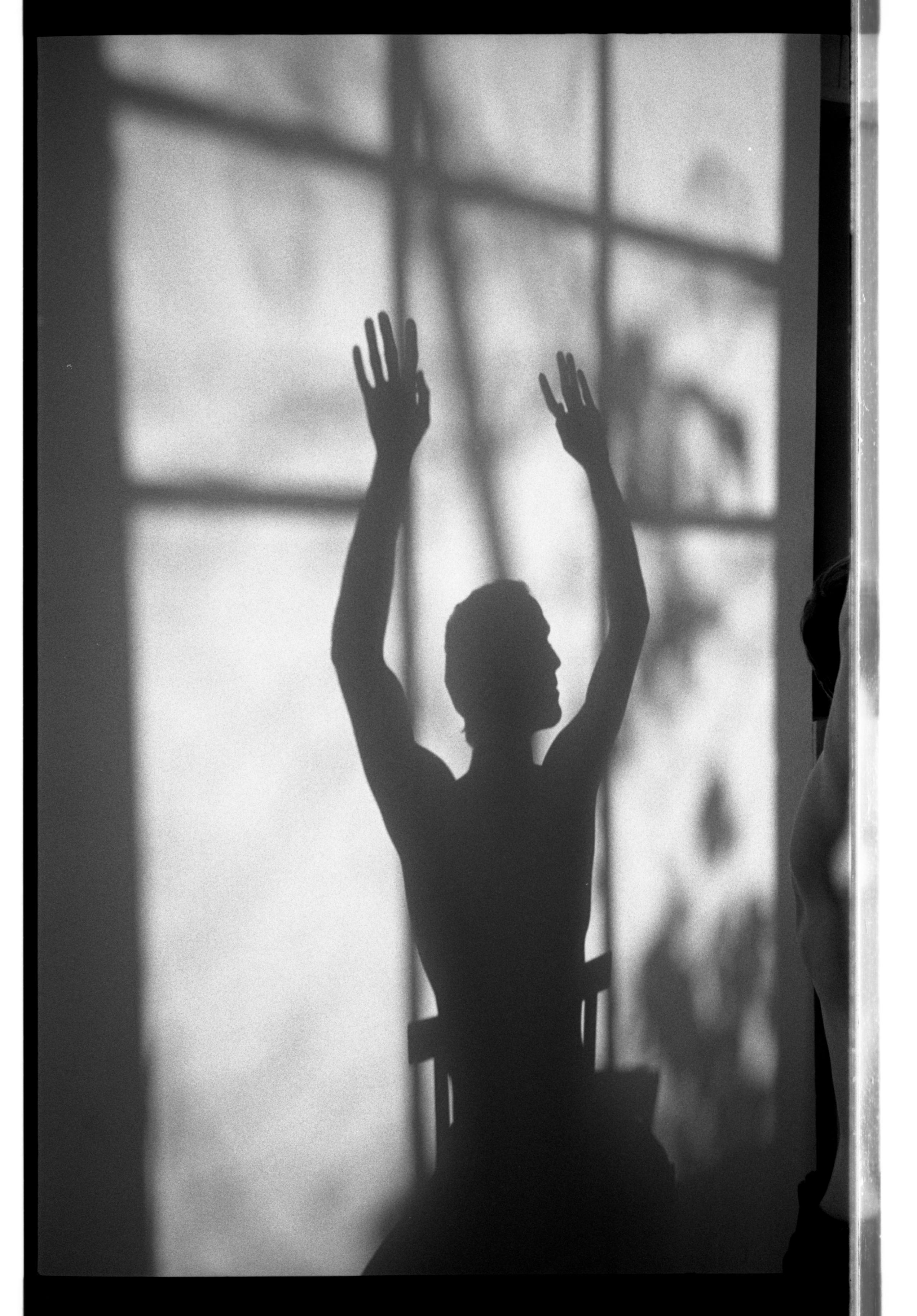 Black and White Photo of a Shadow of a Man Sitting on a Chair with His ...