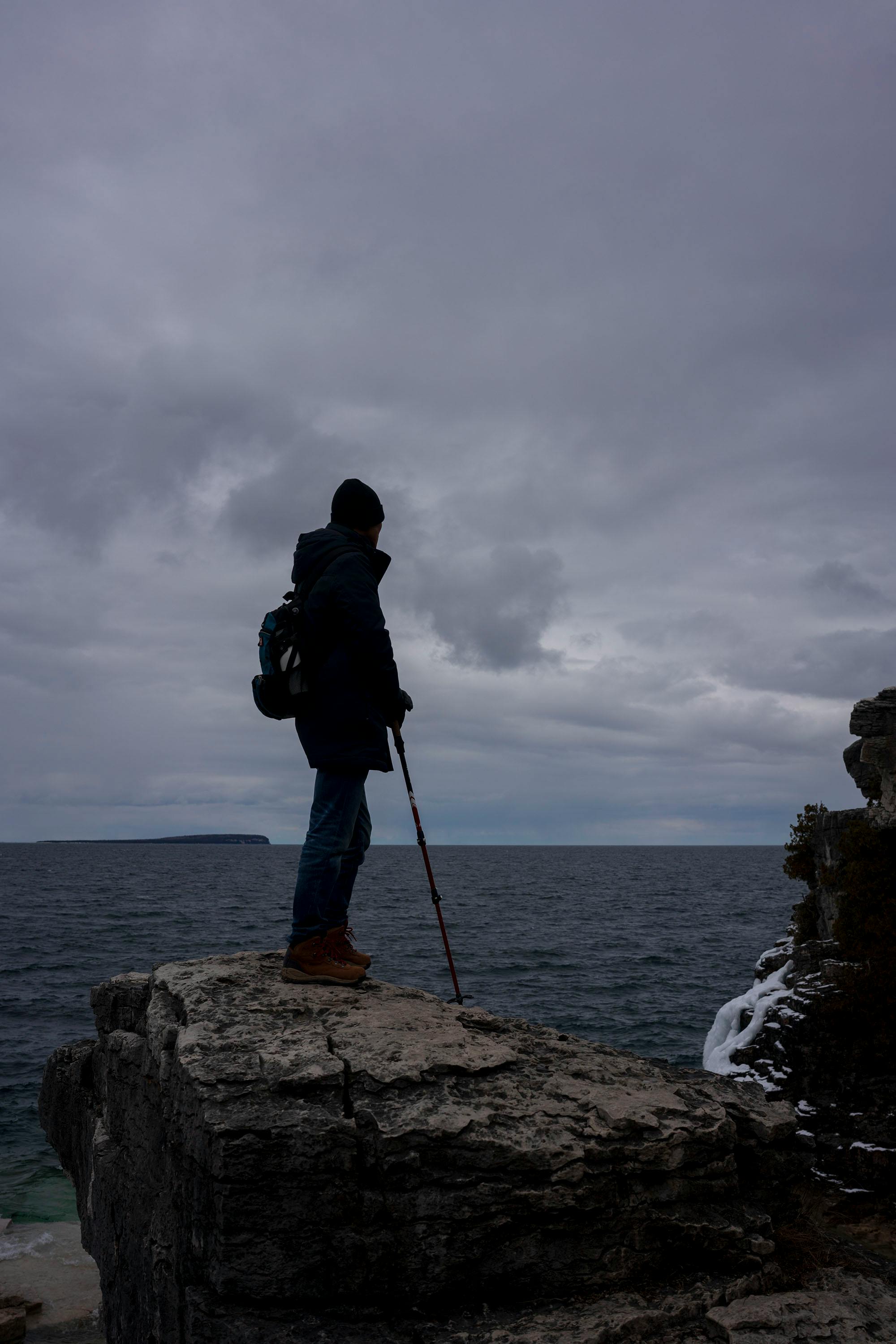 Person Standing on Rock on Sea Shore under Clouds · Free Stock Photo