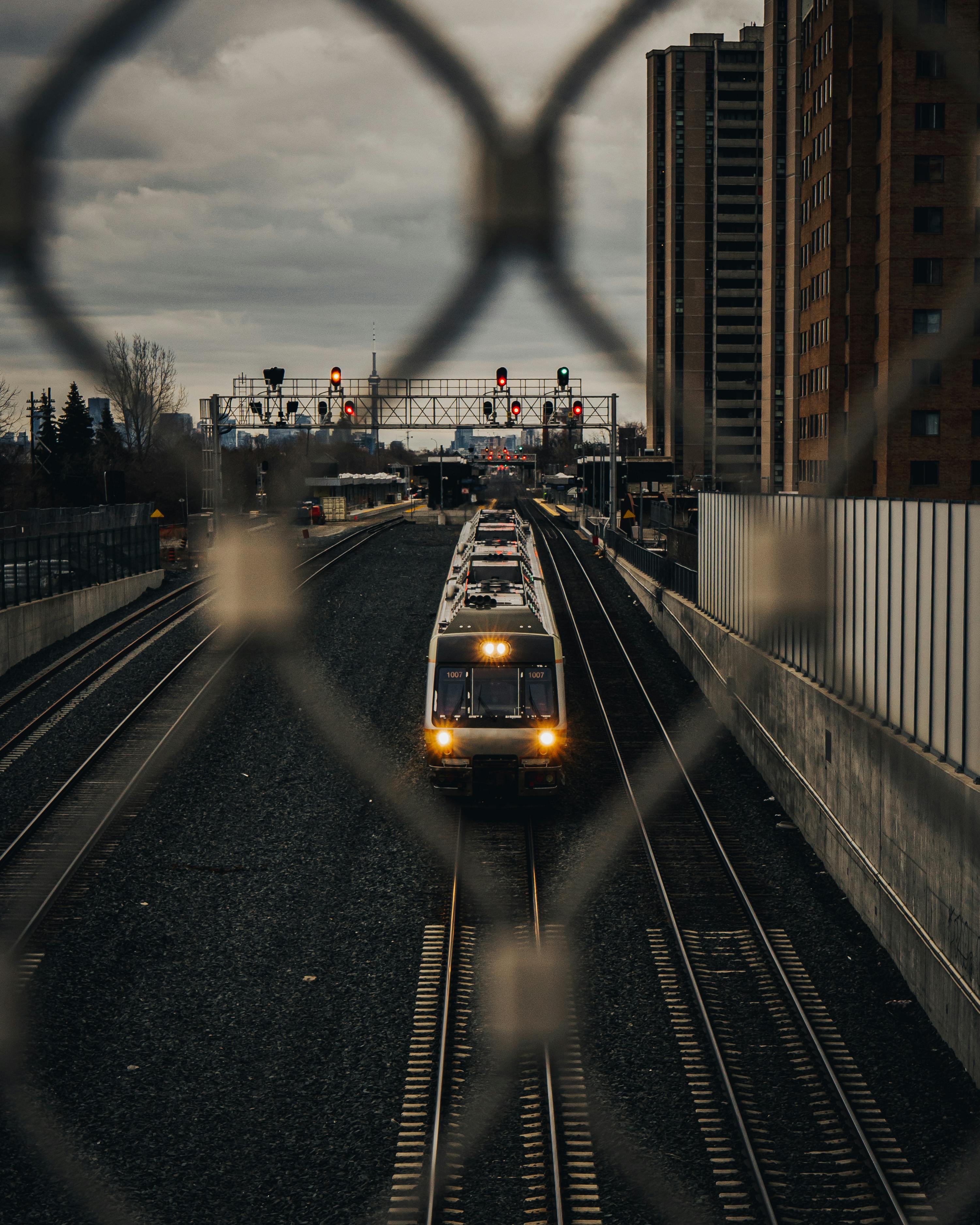 View of a Train from a Bridge with a Chain Fence in City · Free Stock Photo