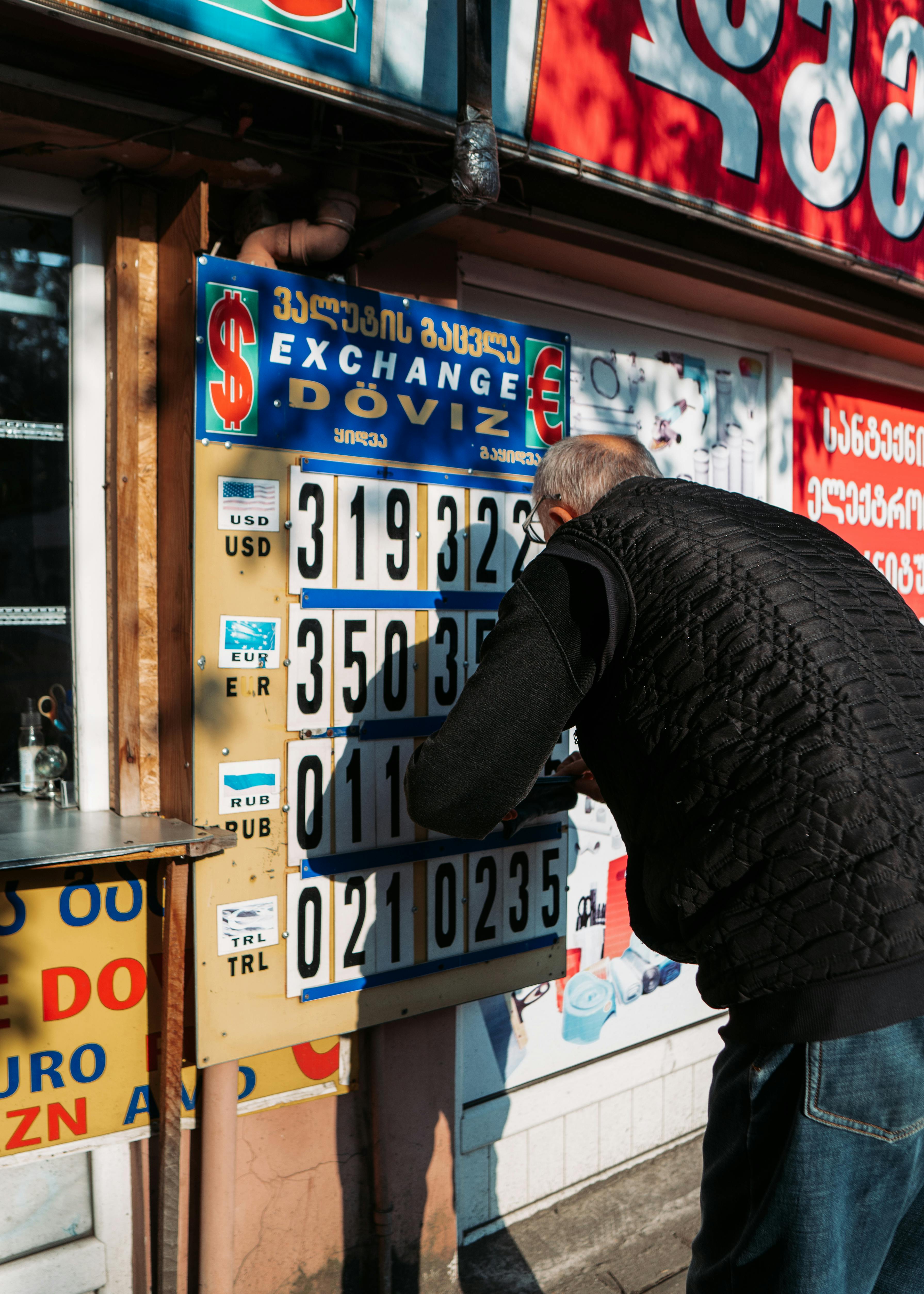 Man by Wall of Money Exchange Building · Free Stock Photo