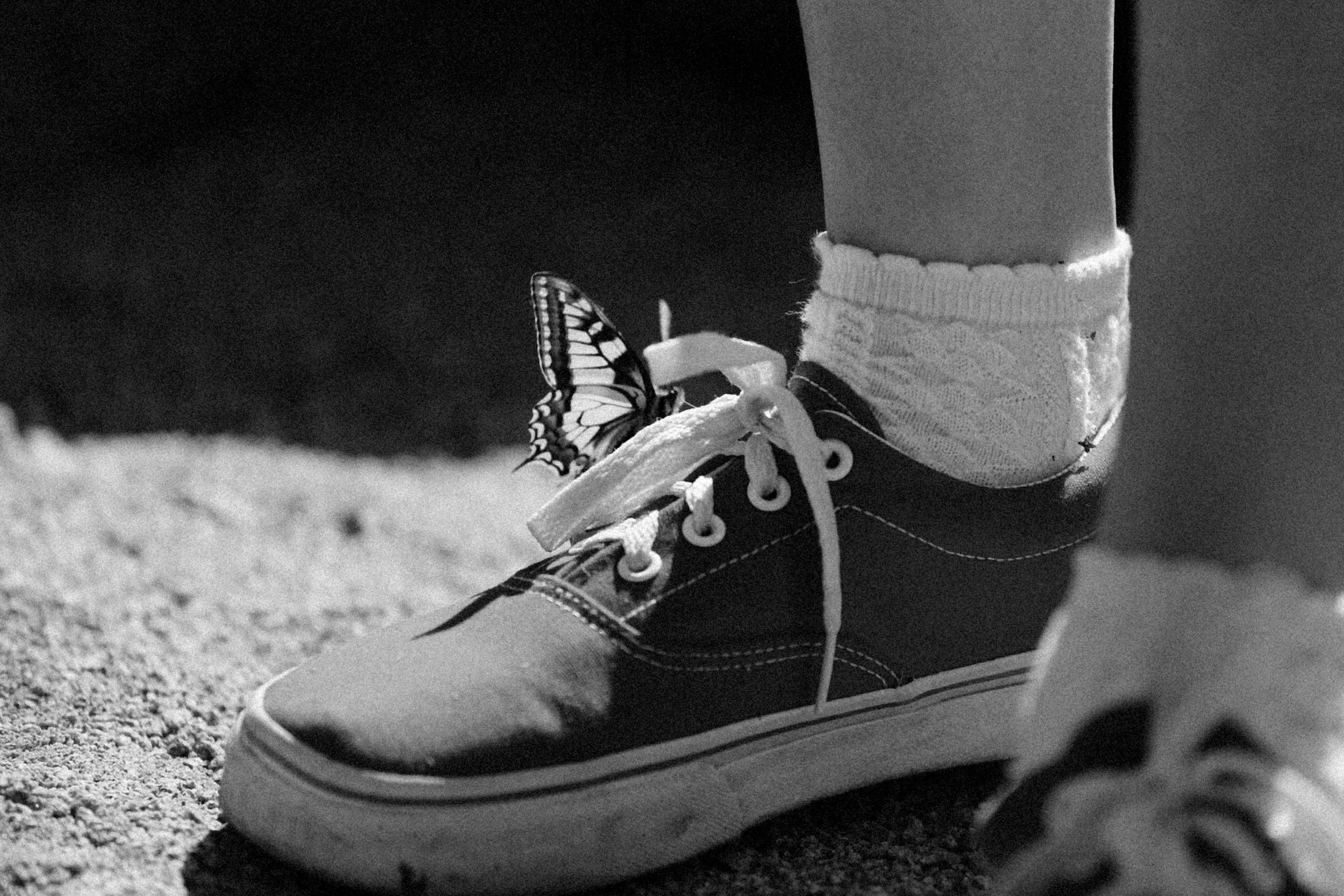 Crop person with sneakers on pavement ground · Free Stock Photo