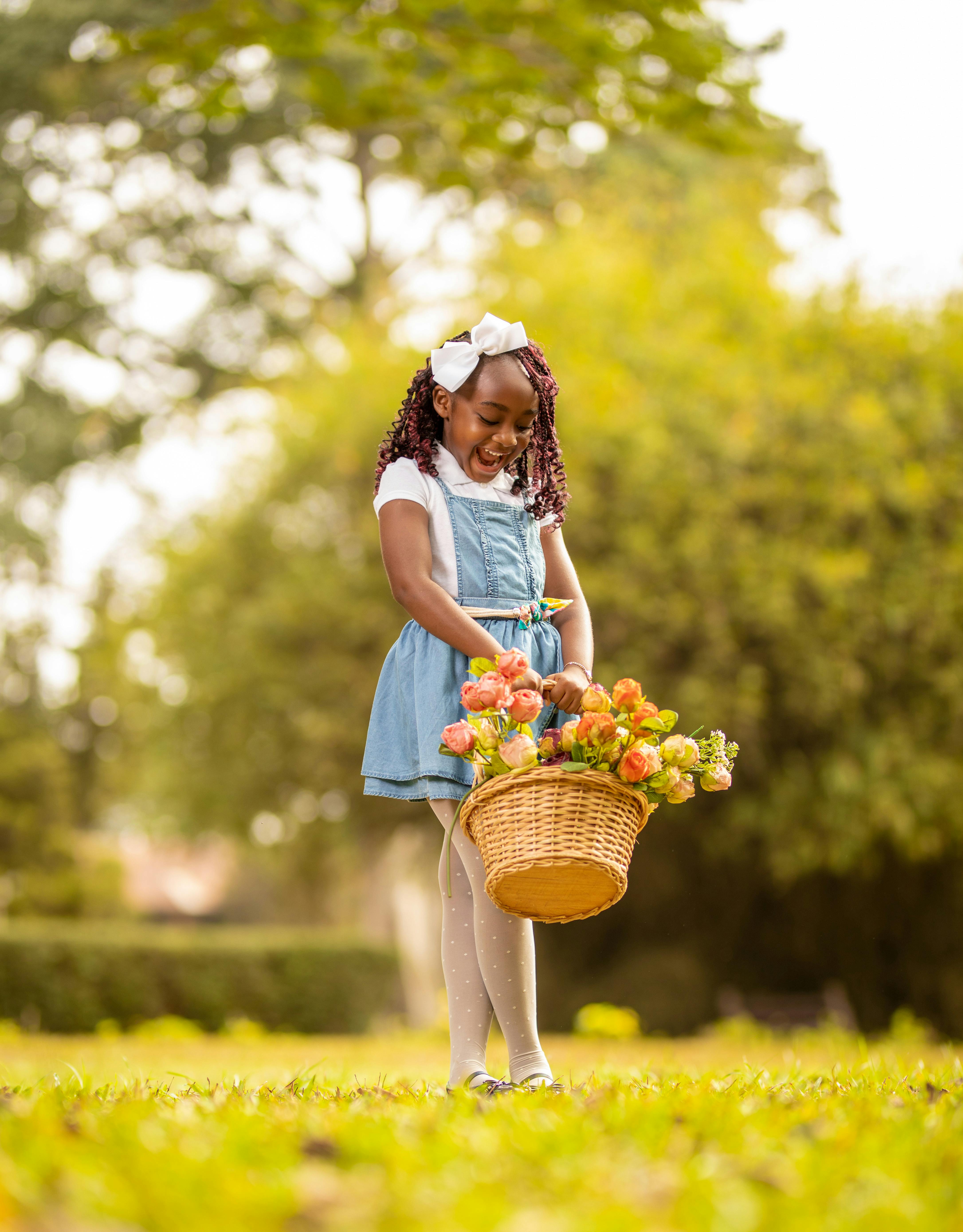A Young Girl Carrying a Basket with Flowers · Free Stock Photo
