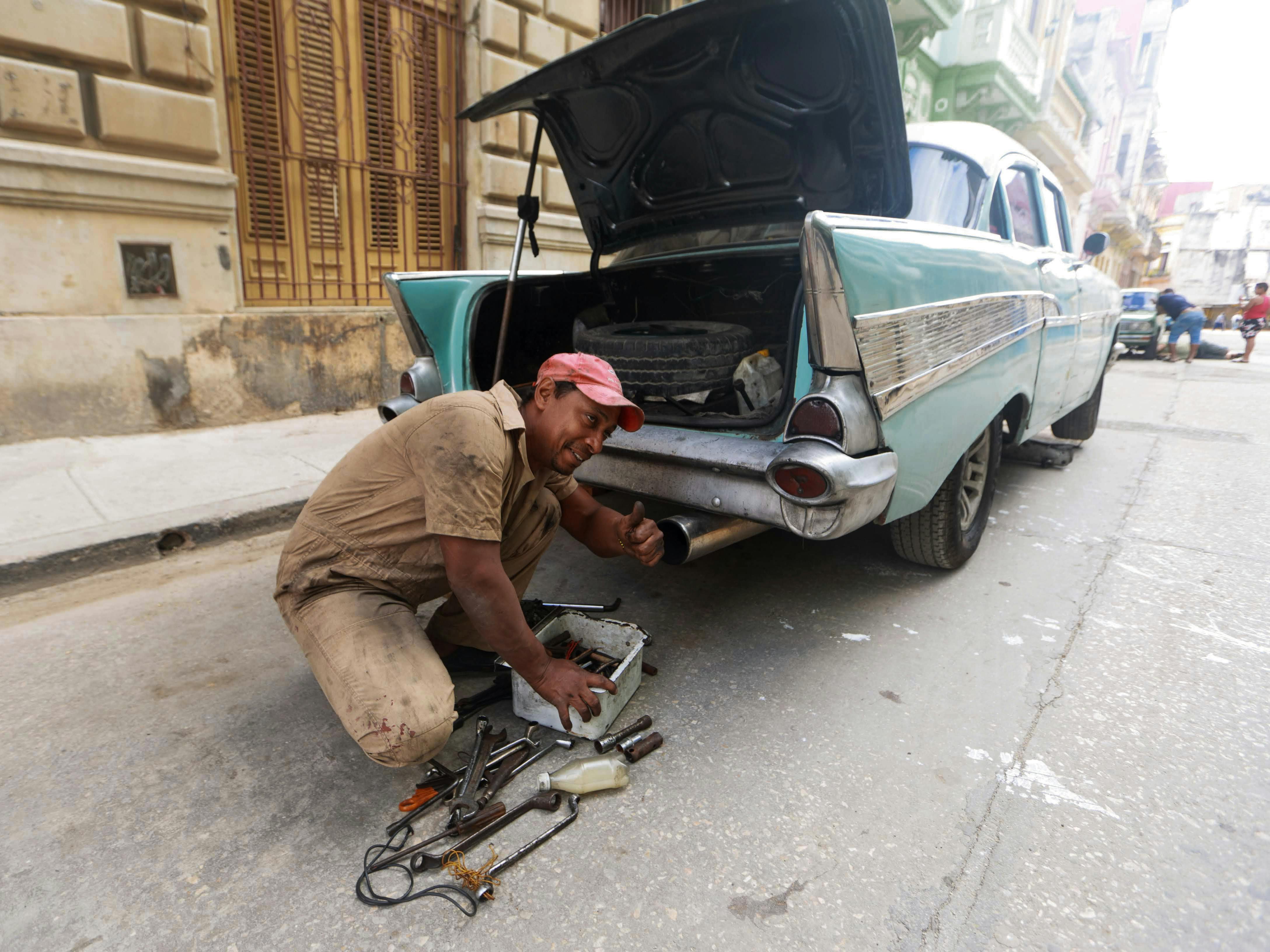 Photo of a Mechanic Repairing a Broken Car on a Street · Free Stock Photo