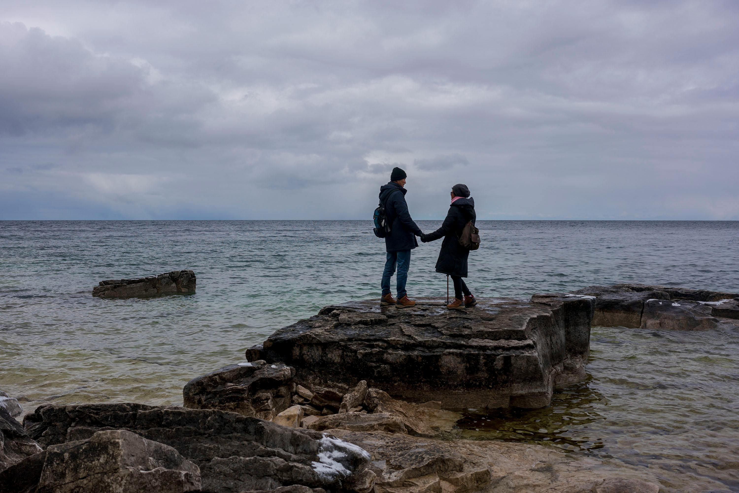 Couple Standing on Rock Holding Hands · Free Stock Photo